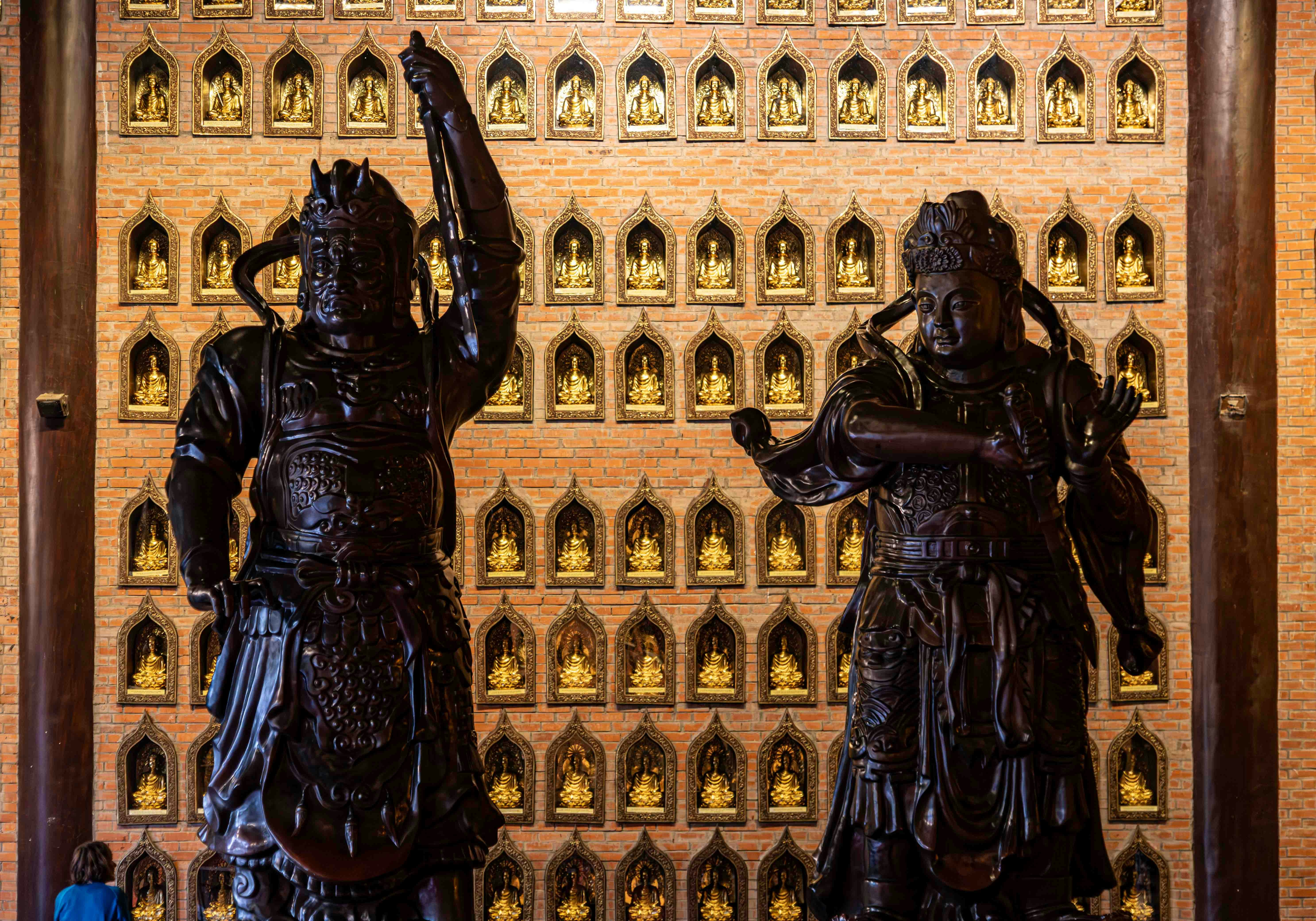 Guardians of the Gallery: Dark Statues Against a Grid of Sacred Nooks