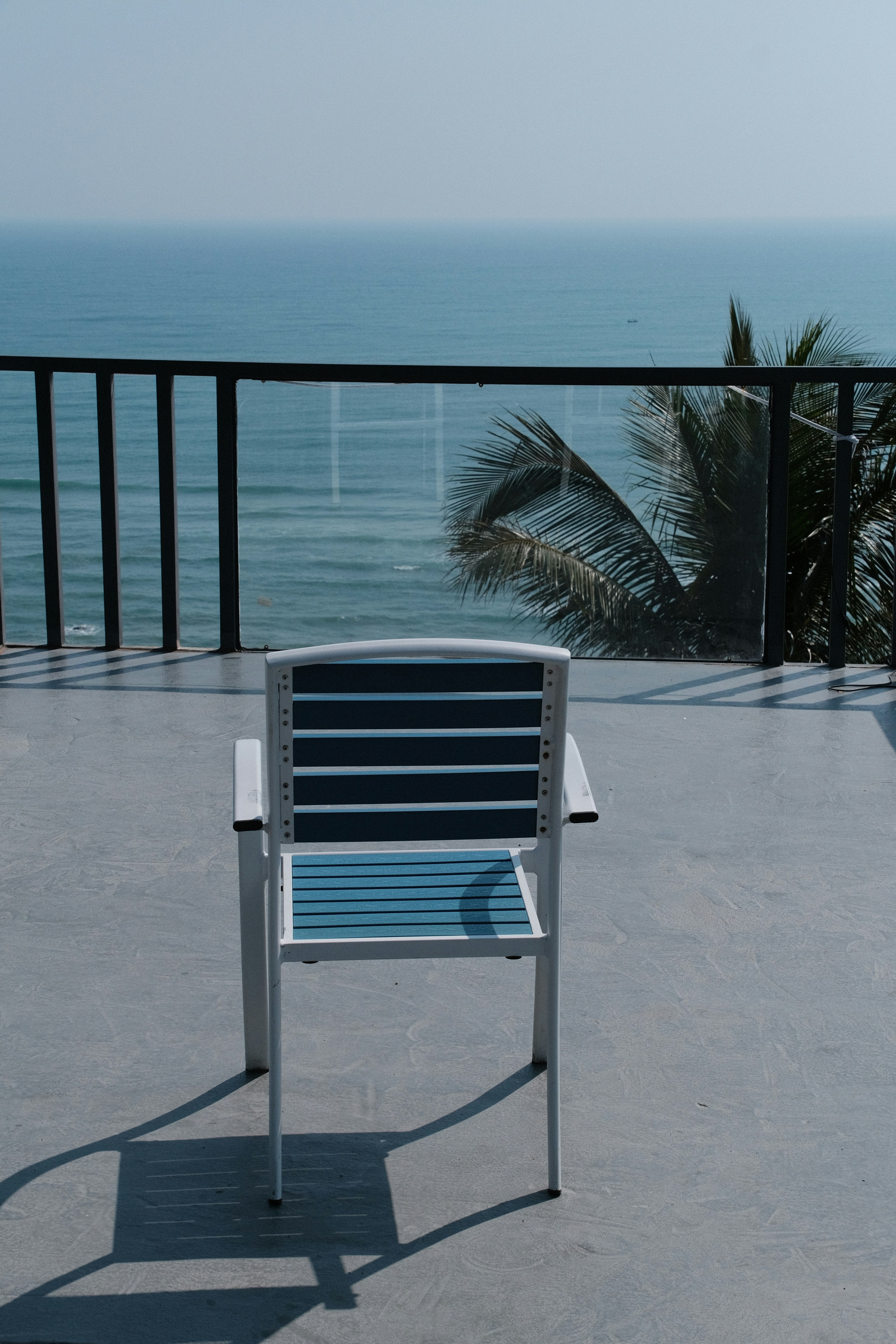 Solitary Blue Chair Facing the Ocean Horizon