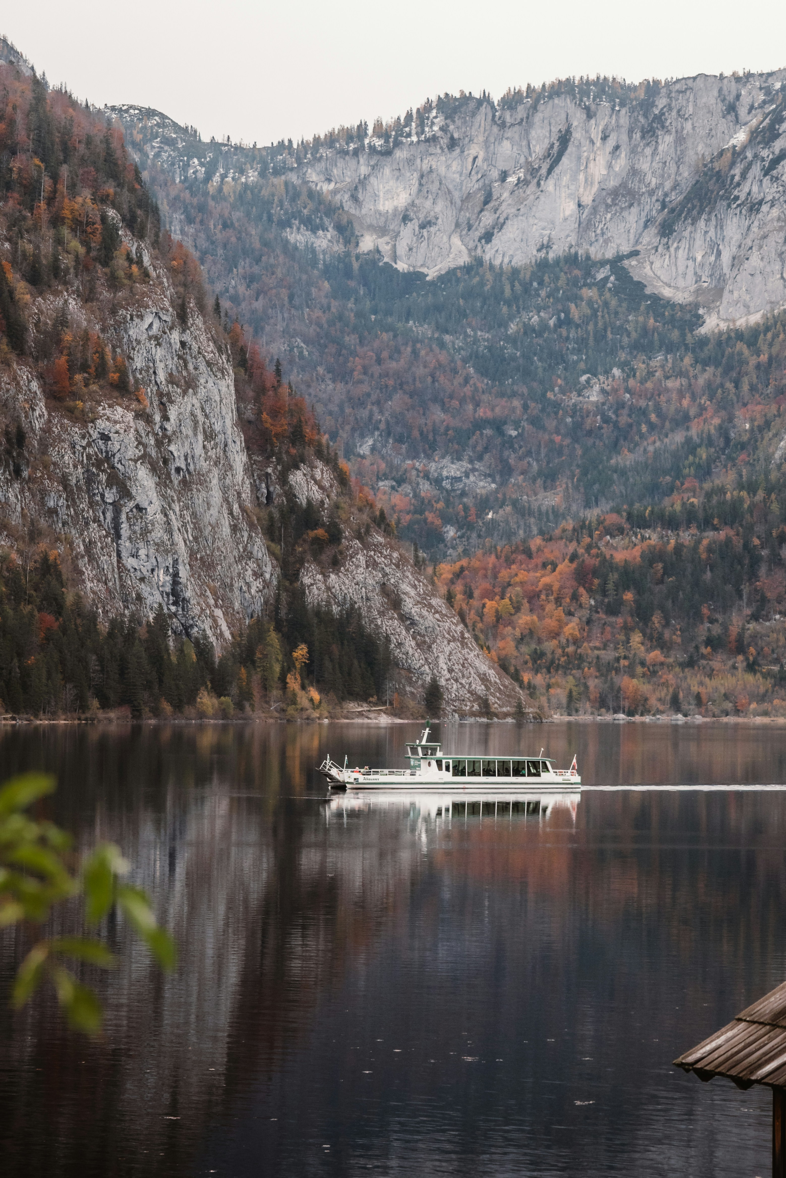 Silent Passage: A White Boat Traverses a Mountain Lake at Dusk