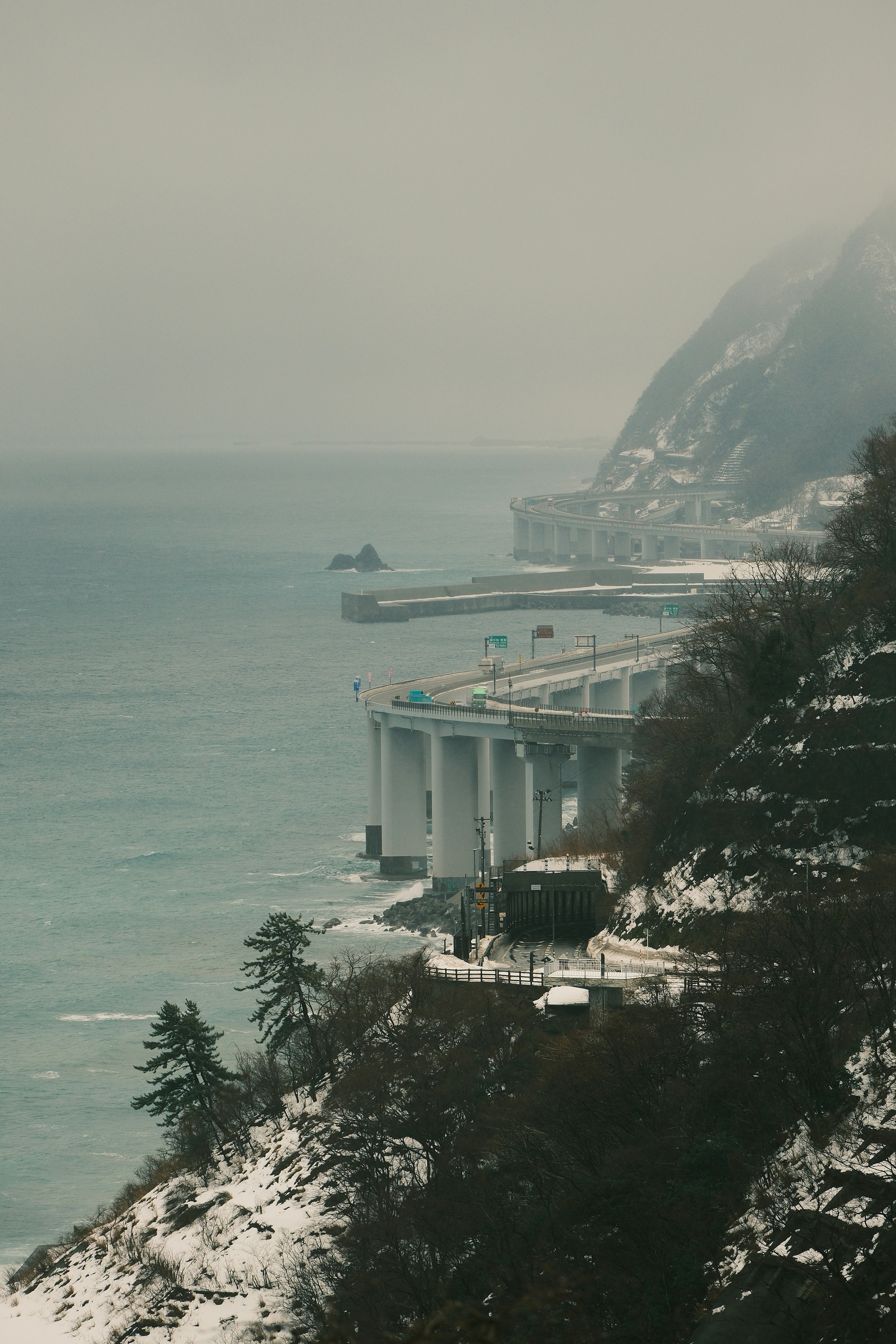Snowy Coastal Viaduct: A Quiet Drive Along the Misty Cliffs