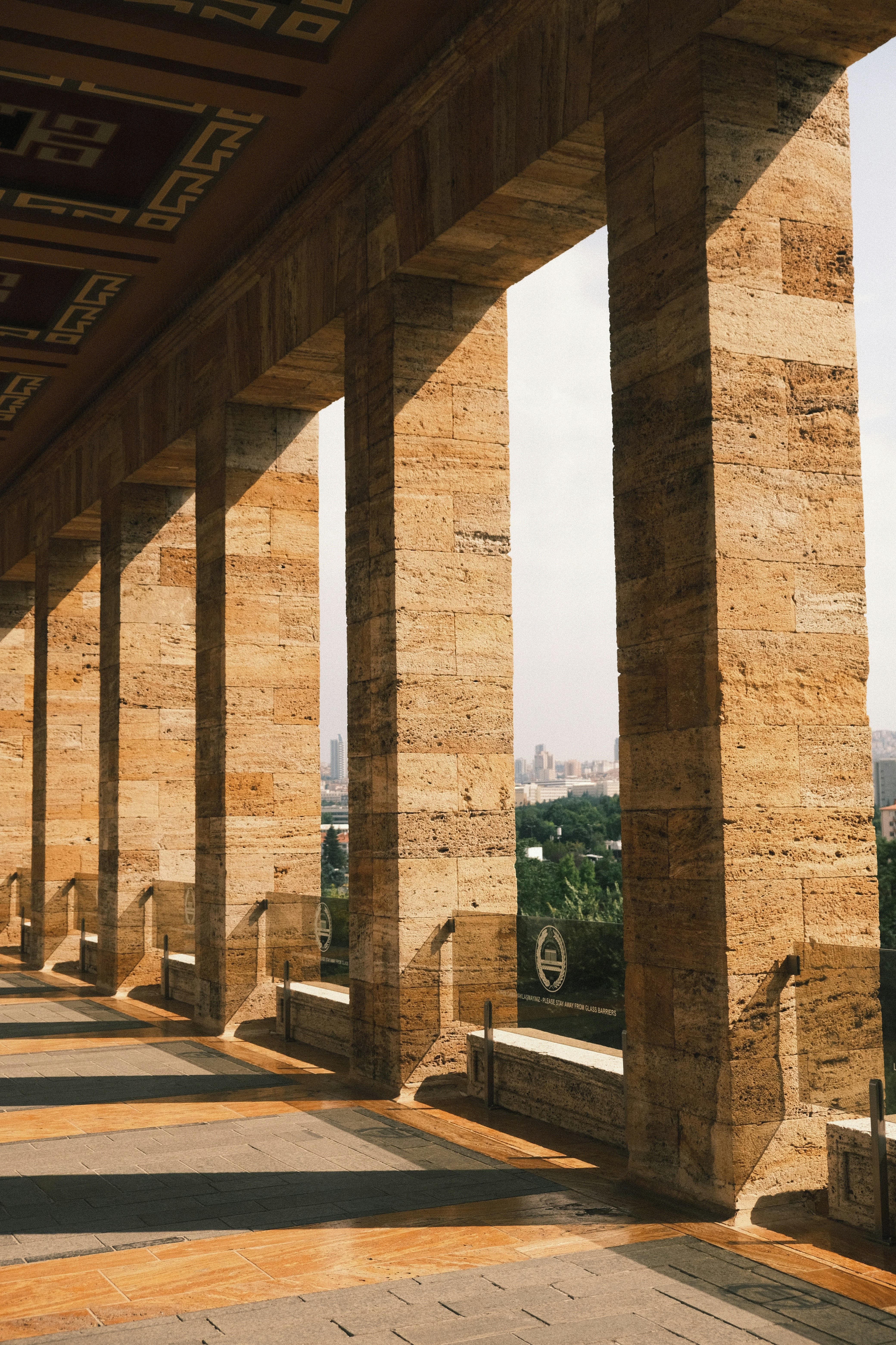 Stone Colonnade Framing a Distant Cityscape at Golden Hour