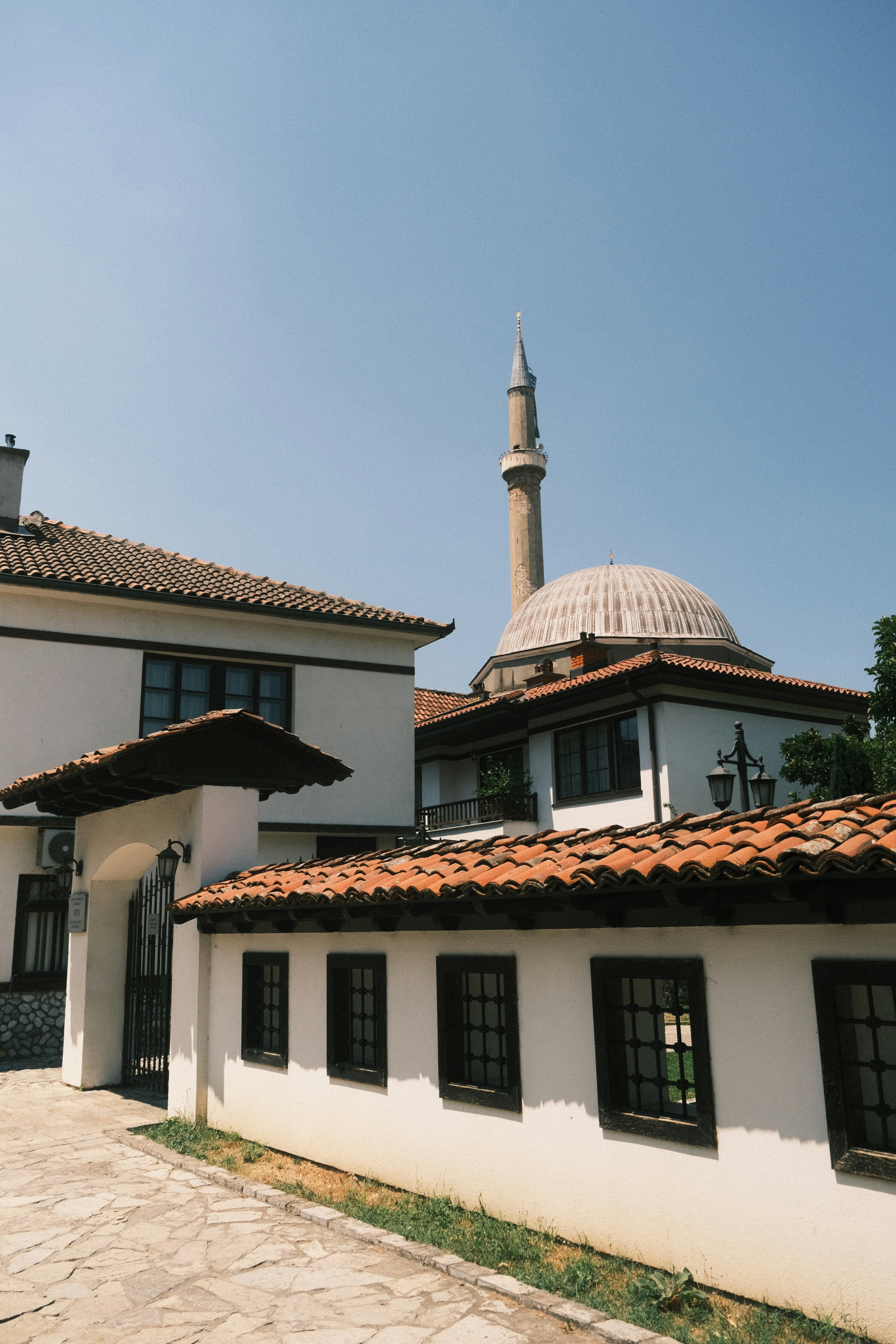 Terracotta Rooftops and a Domed Mosque under a Clear Sky