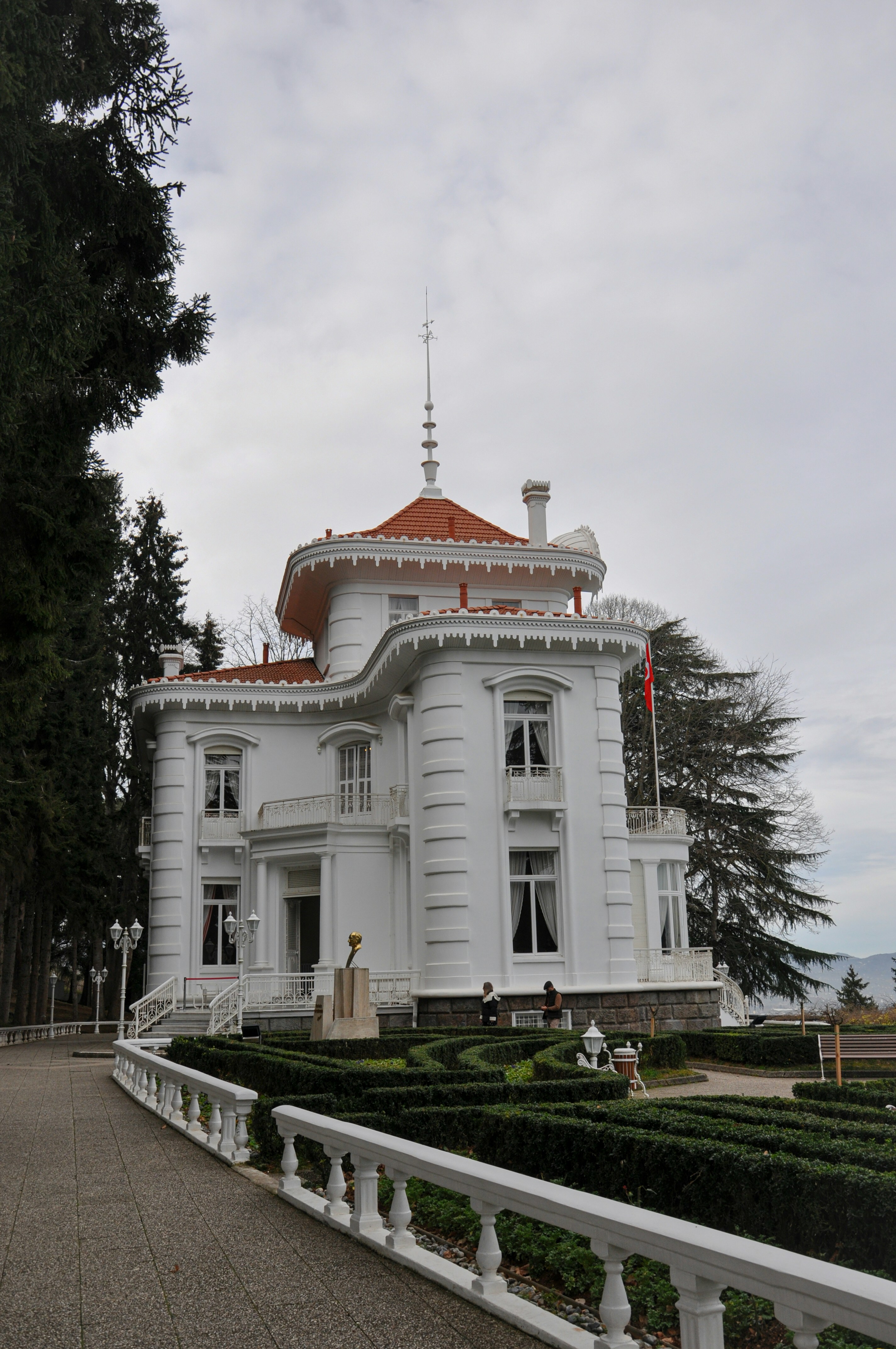 Ornate White Villa Wreathed in Icicle Trim Against a Park of Sloping Hedges
