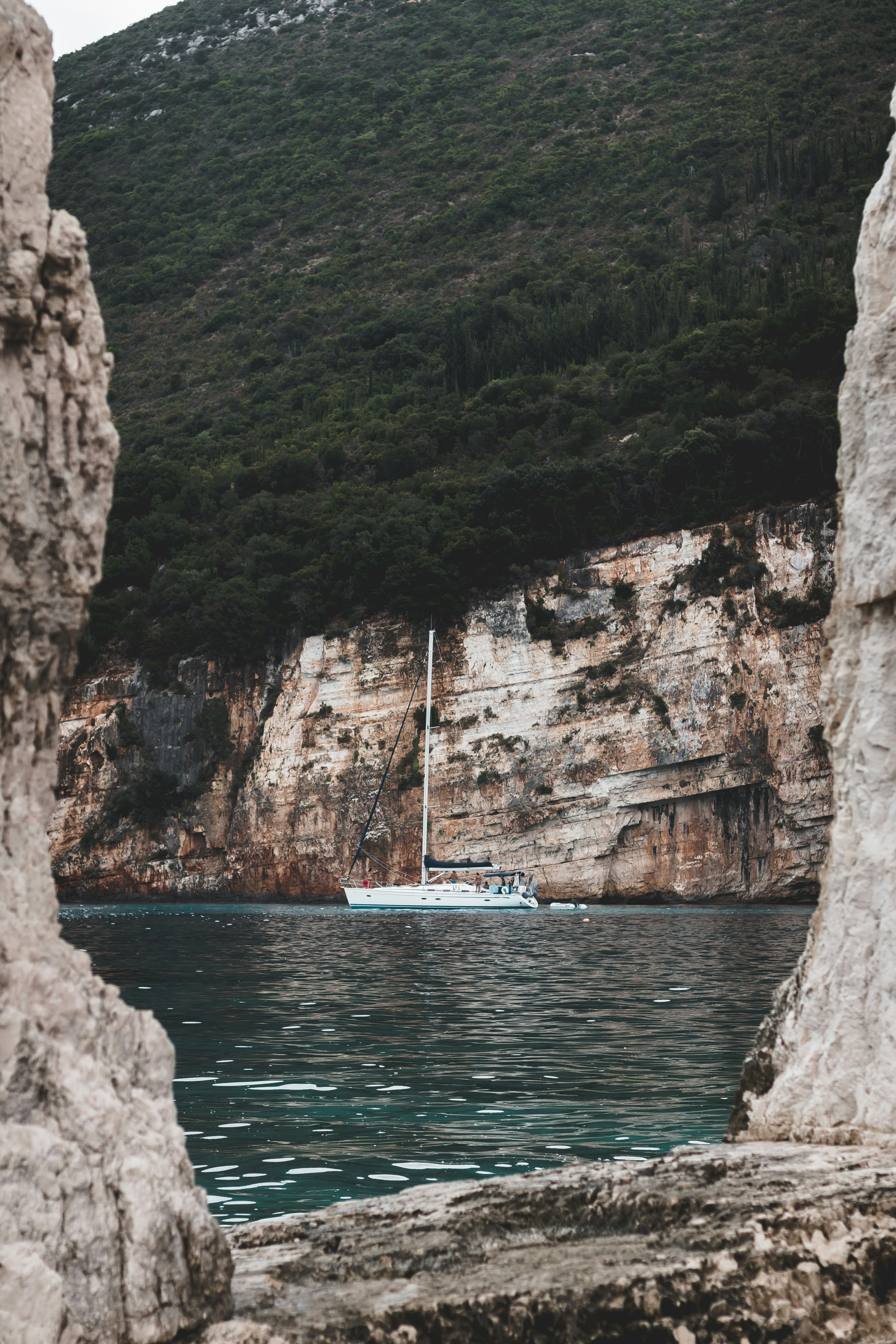 Sailboat Quietly Idling in a Narrow Coastal Gorge