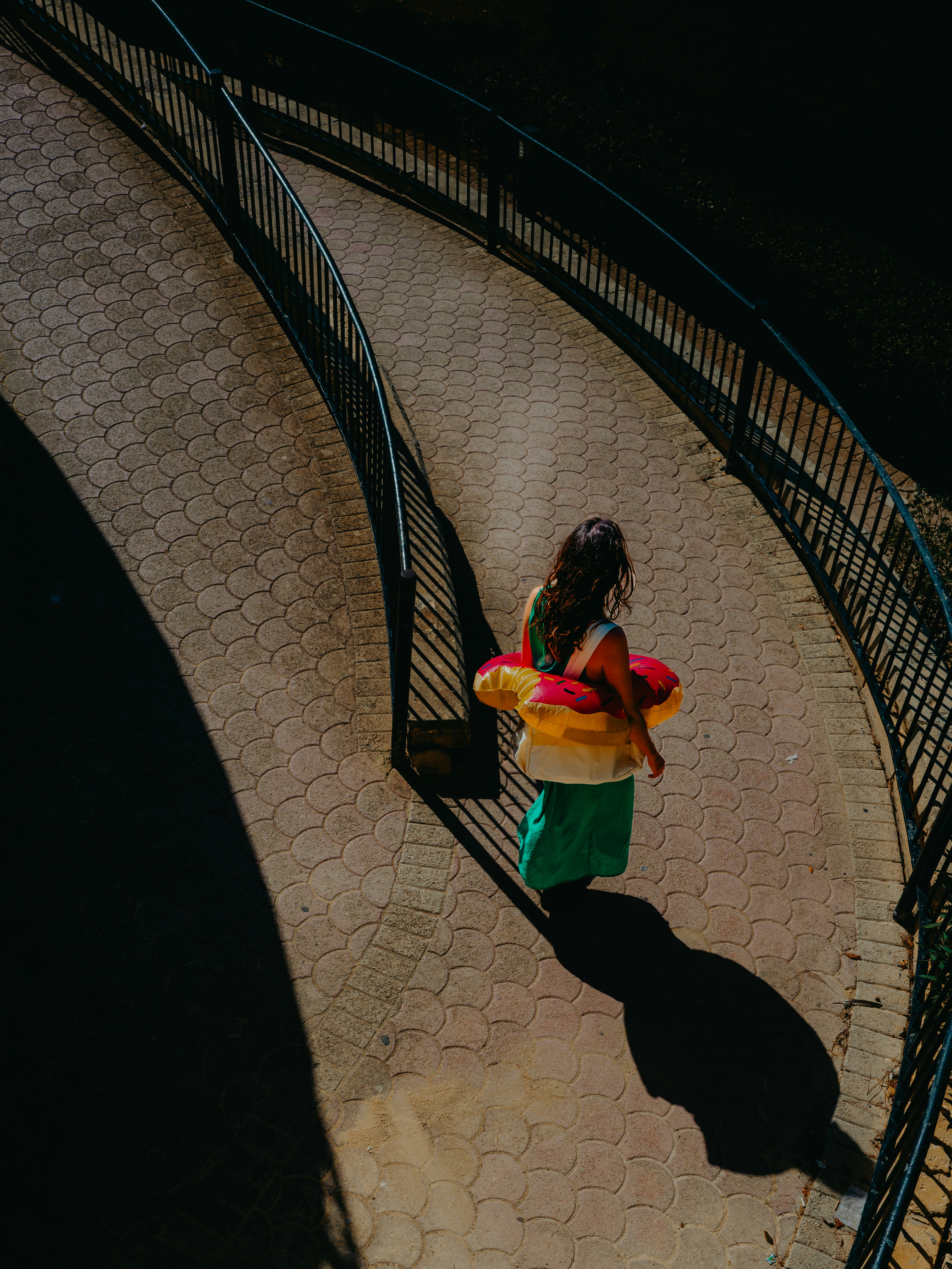 Rope-braided Path: A swimmer in bright attire descends a sunlit spiral walkway