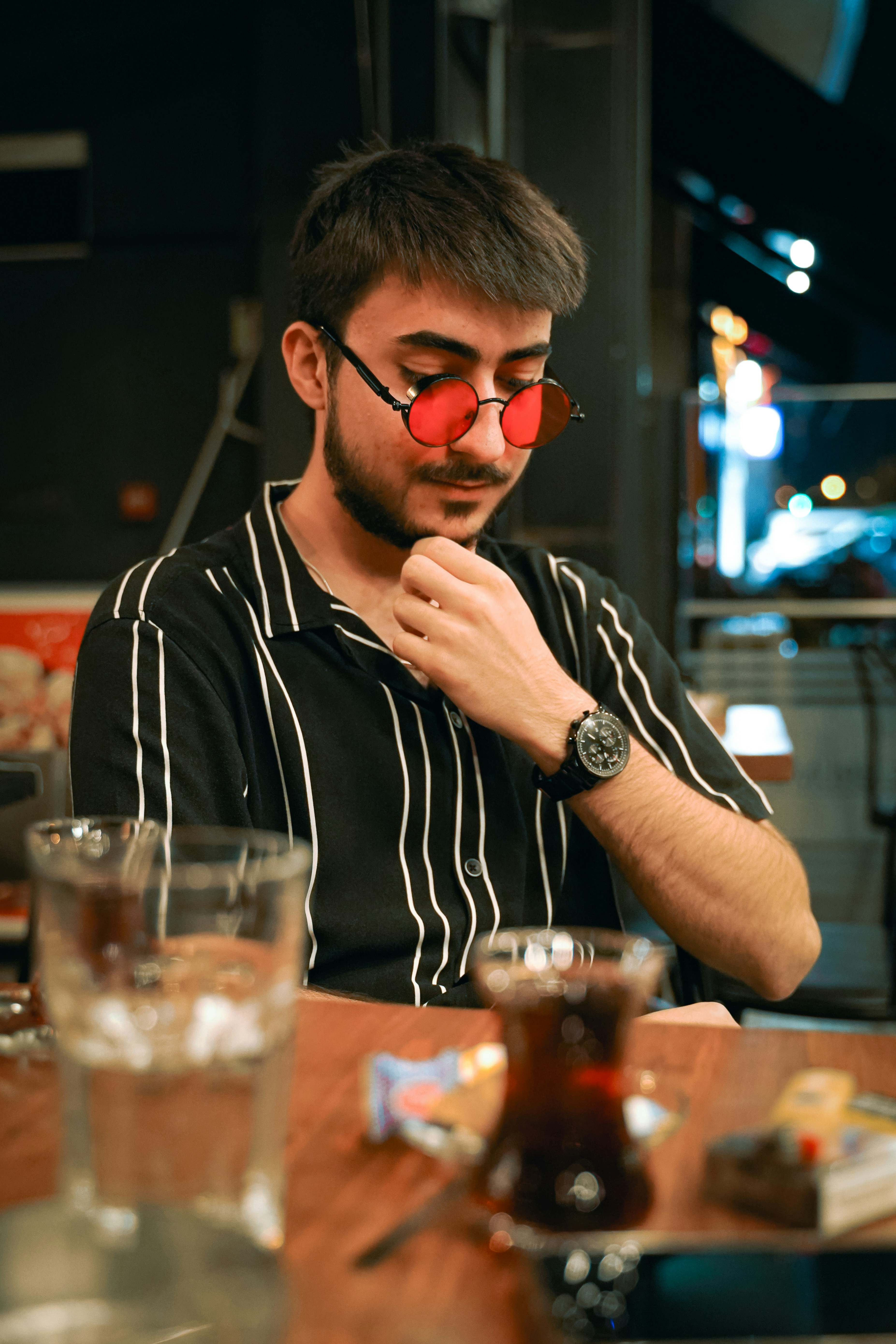 Contemplative Moment: Red-Tinted Glasses and Quiet Introspection