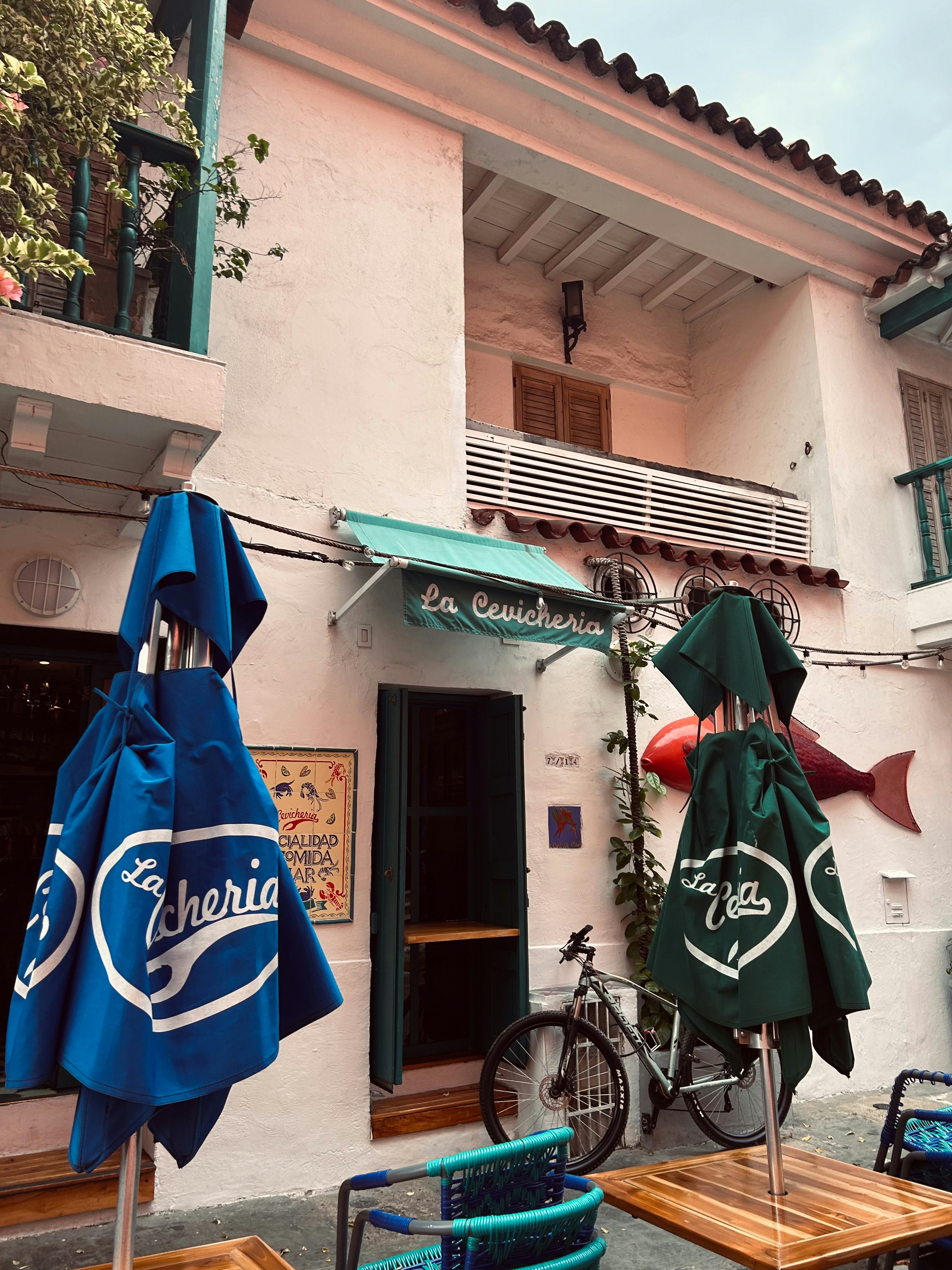 Café Facade with Colorful Awnings and Bicycle Outside a Mediterranean Eatery