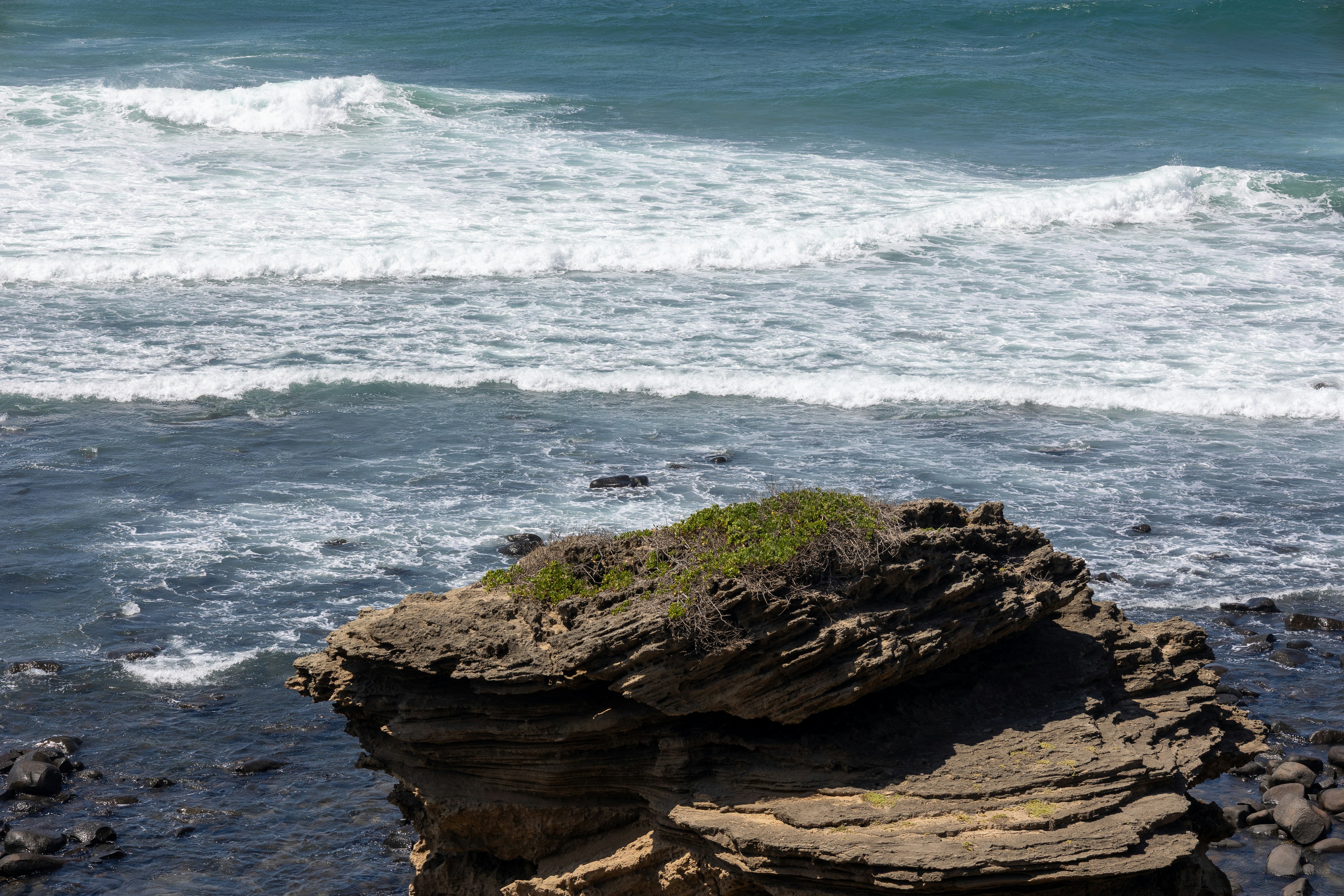 Rocky outcrop greeting the sea under a crescent of foam