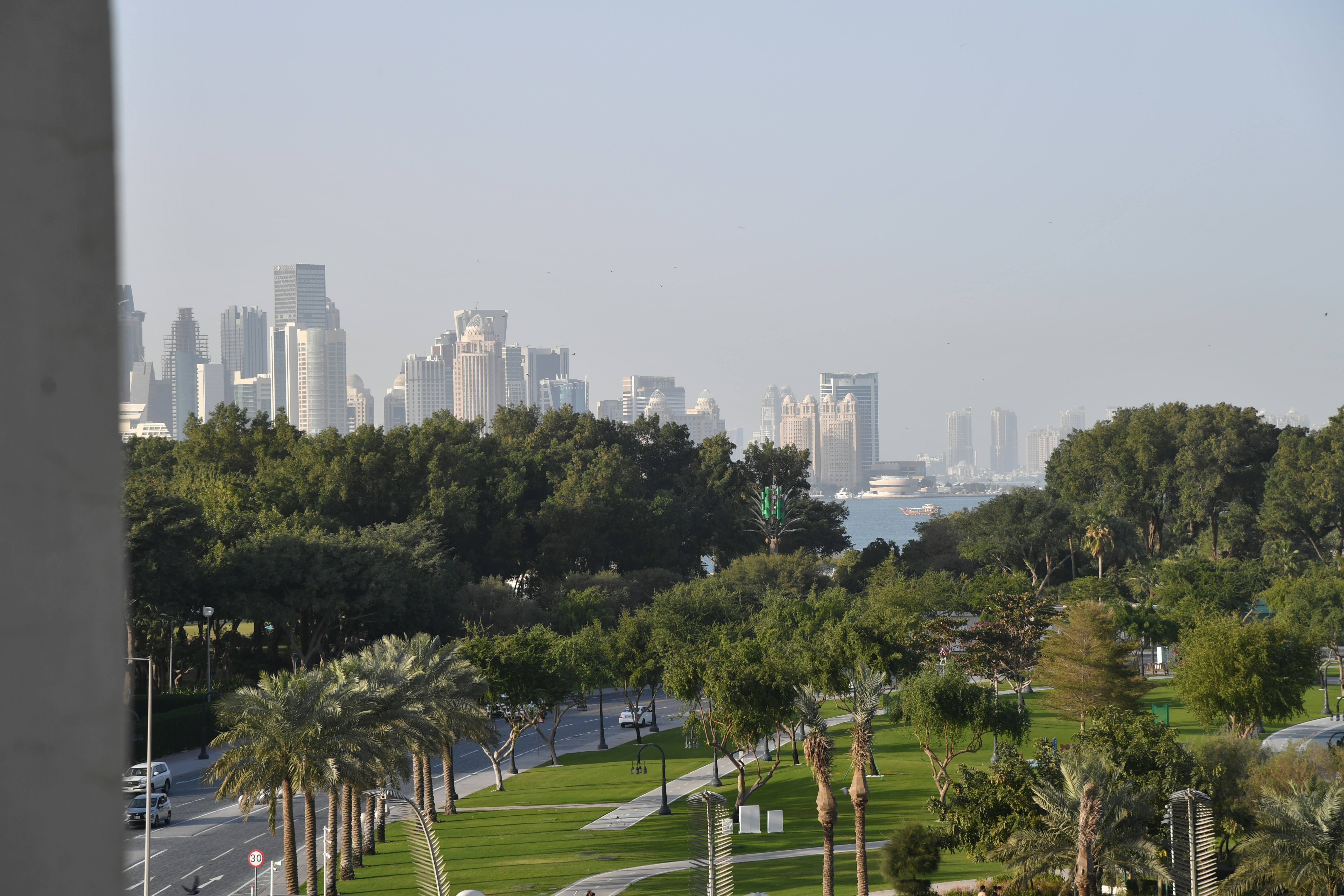 Cityscape in a Green Corridor Seen Beyond a Concrete Edge