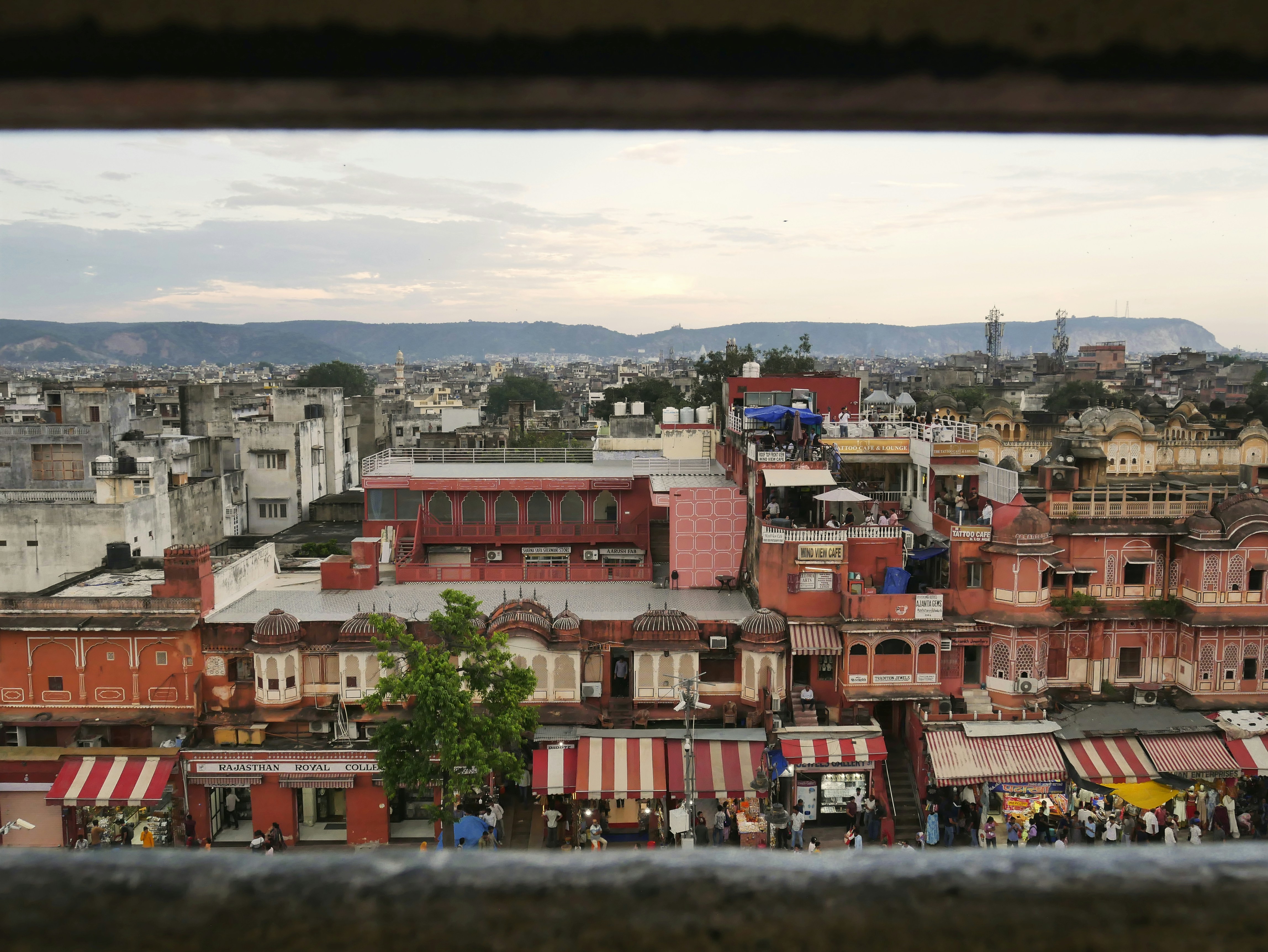 Colorful rooftops and bustling market beneath a distant mountain horizon