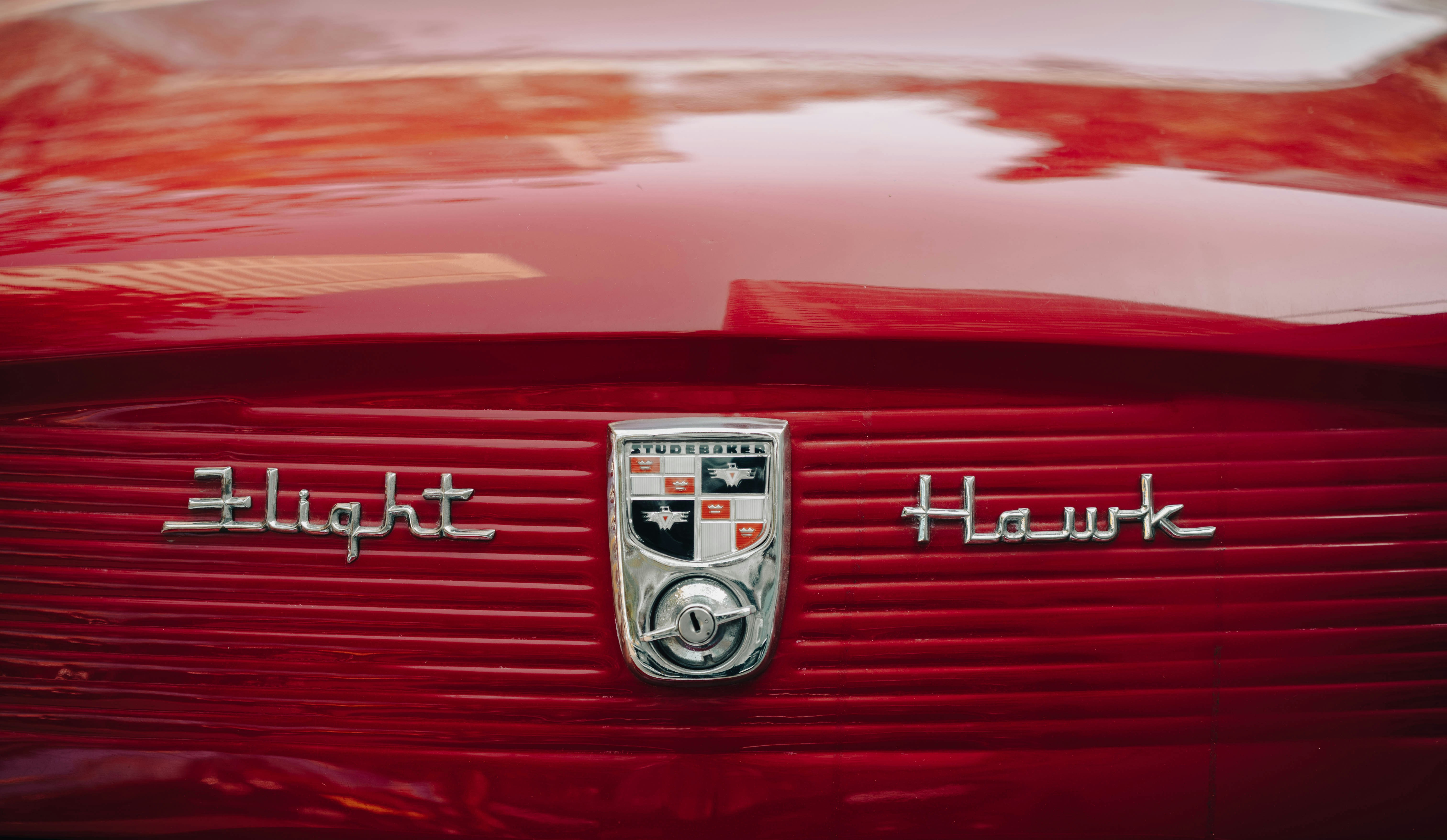 Close-up of a red car's 'flight hawk' emblem.