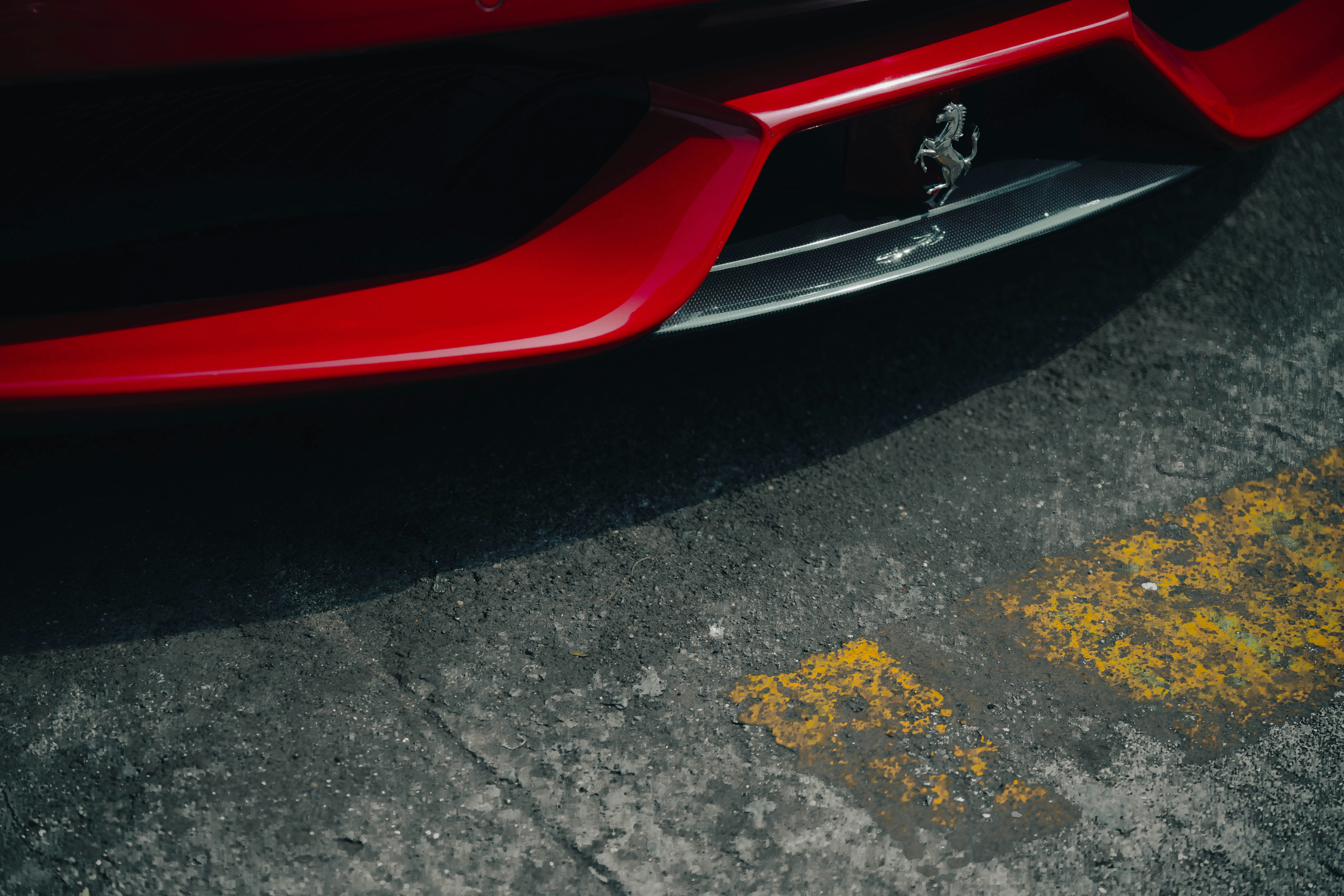 Close-up of a red car's front spoiler and yellow lines