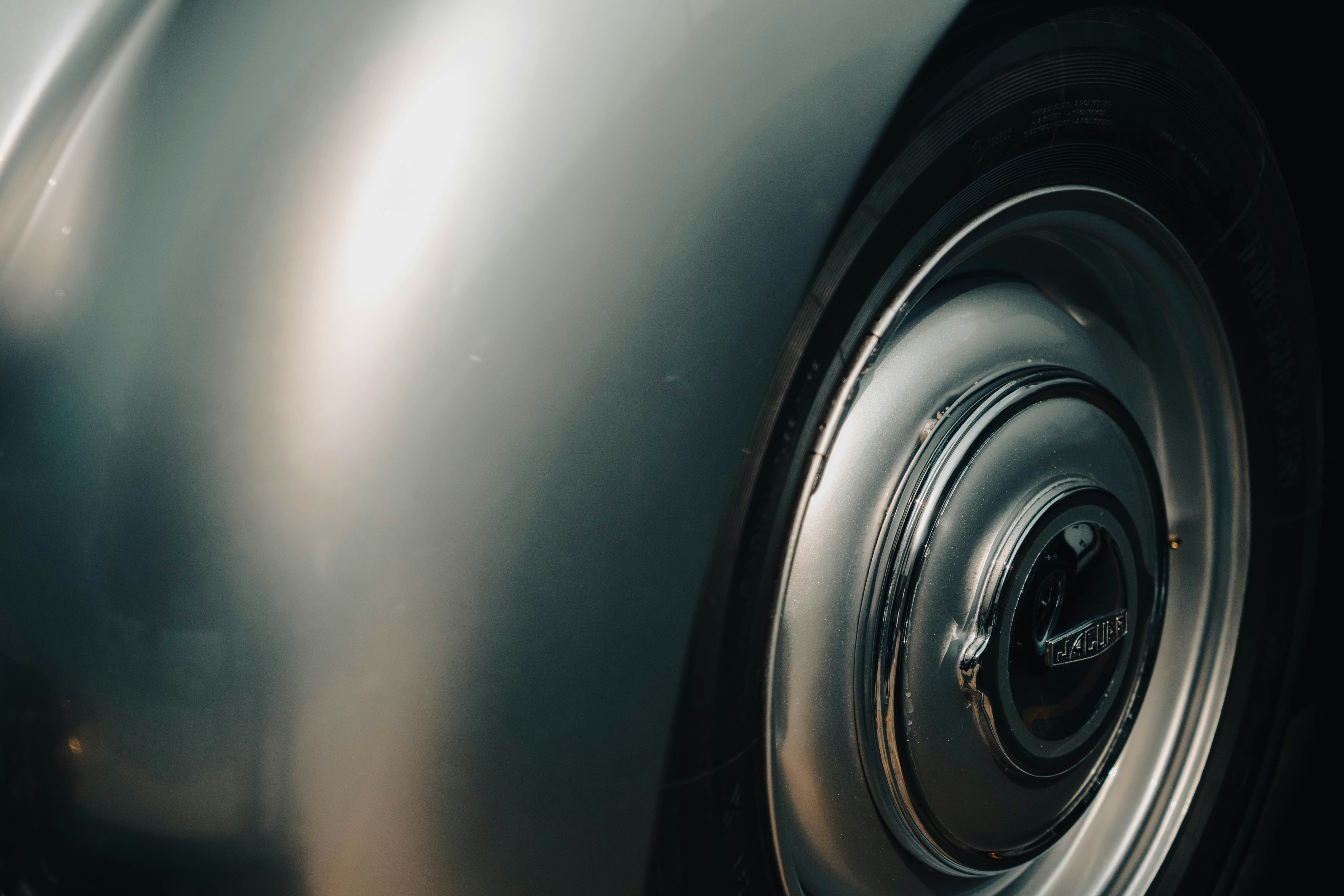 Close-up of a vintage car's silver fender and wheel