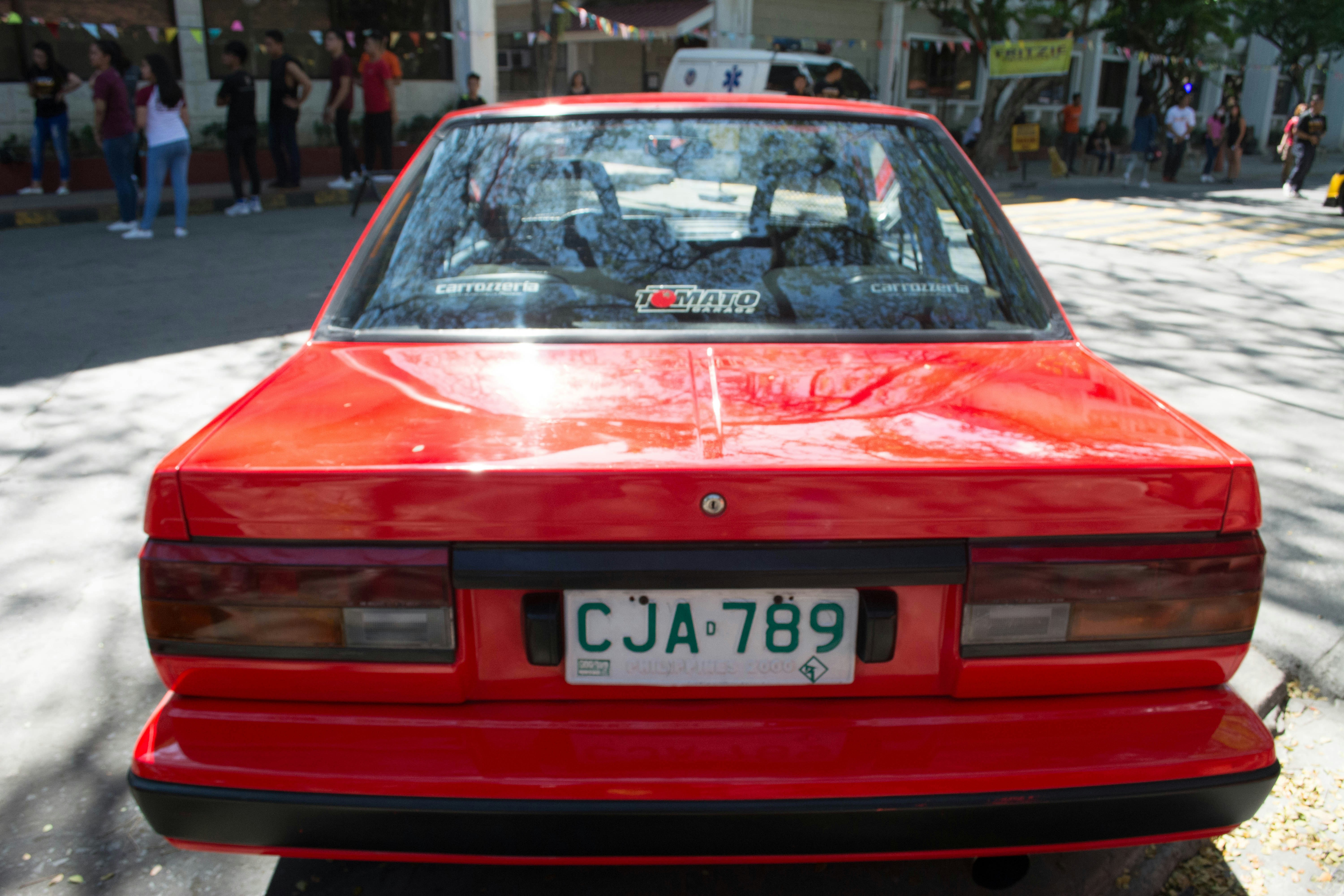 Red Hatchback at a Busy Street: License Plate in Focus