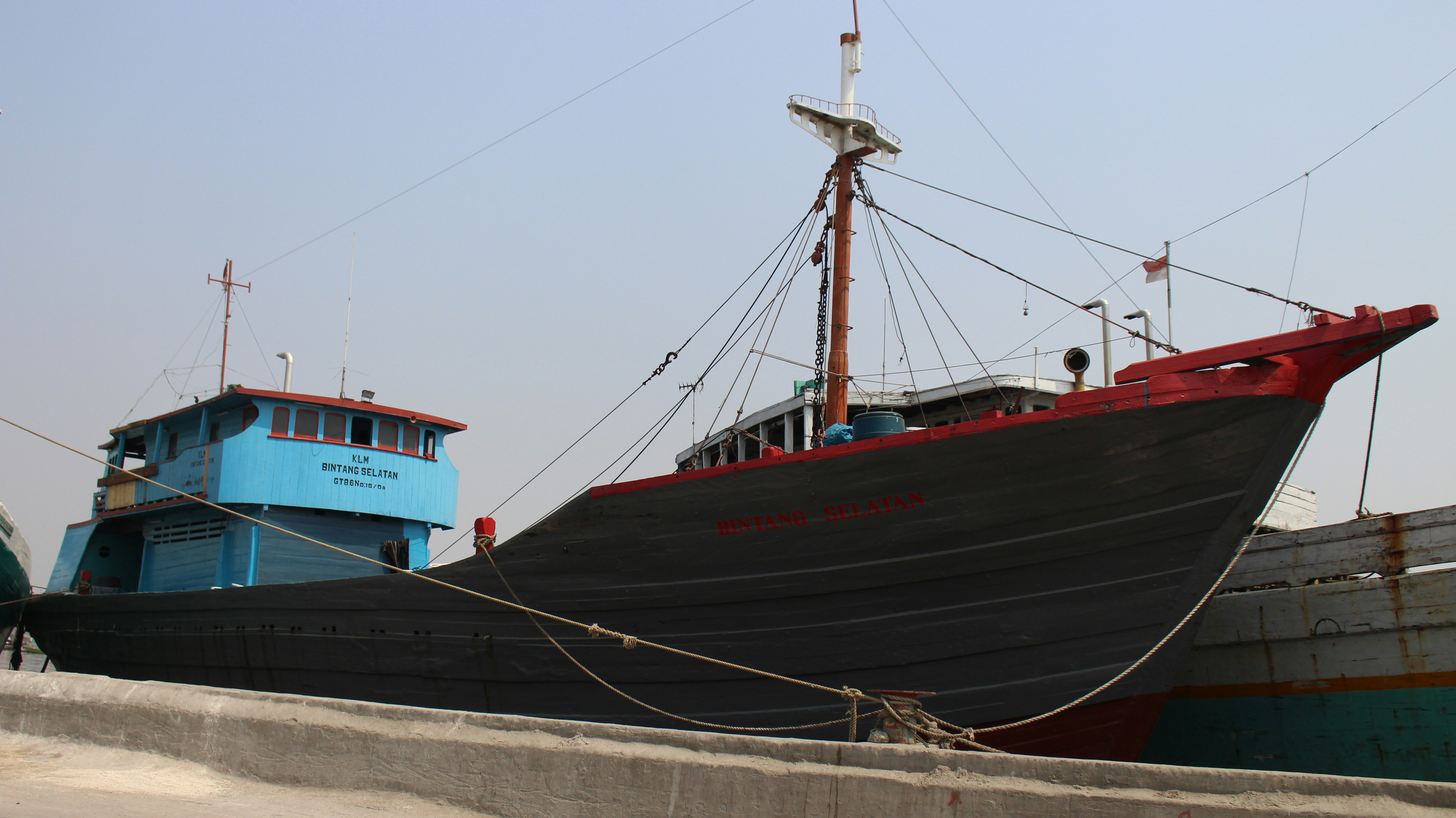 Blue Sailor: A Vessel Resting at Docks Under Clear Sky