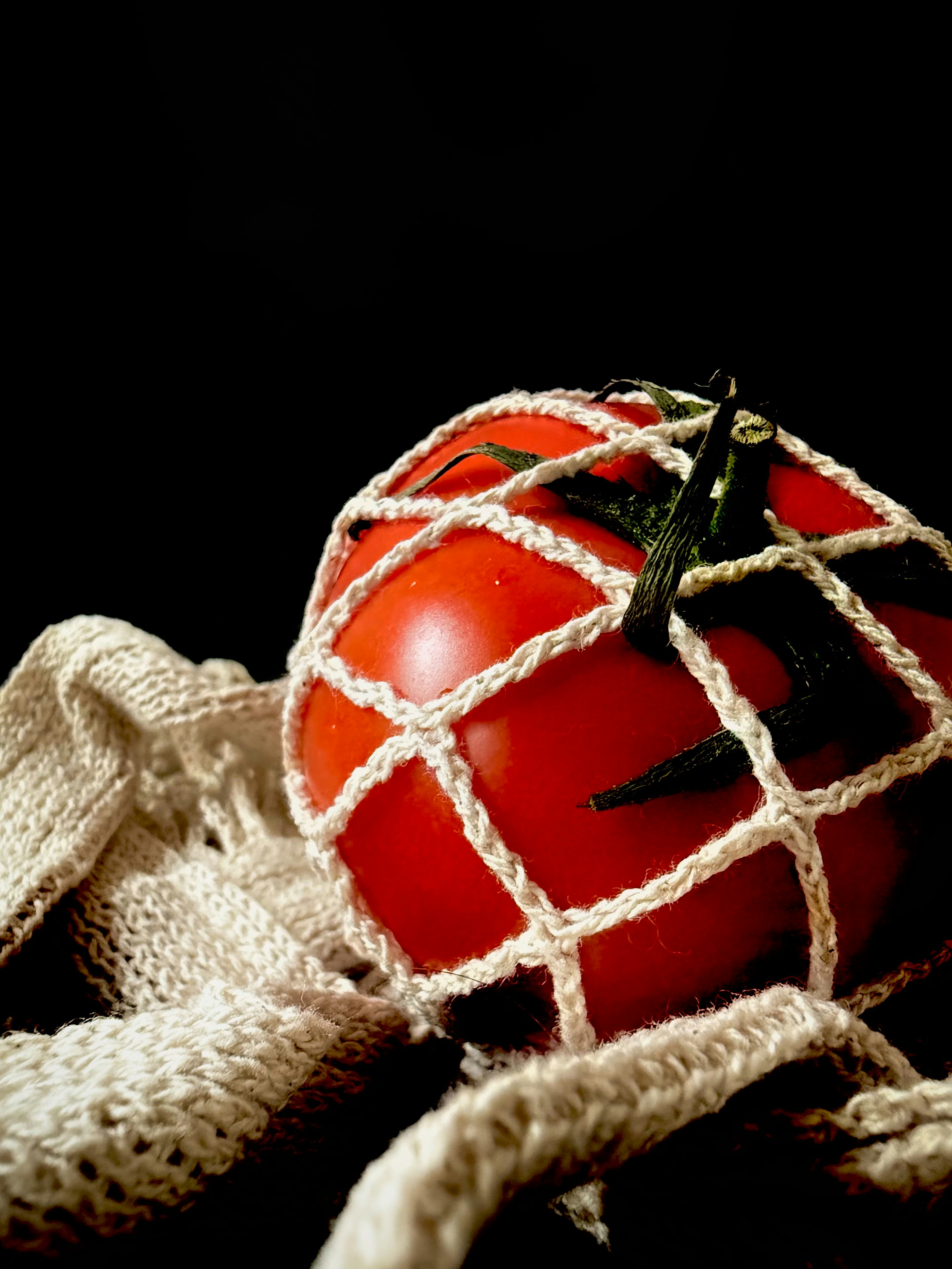 Red Globe Entrapped: Tomato in a Knit Cage
