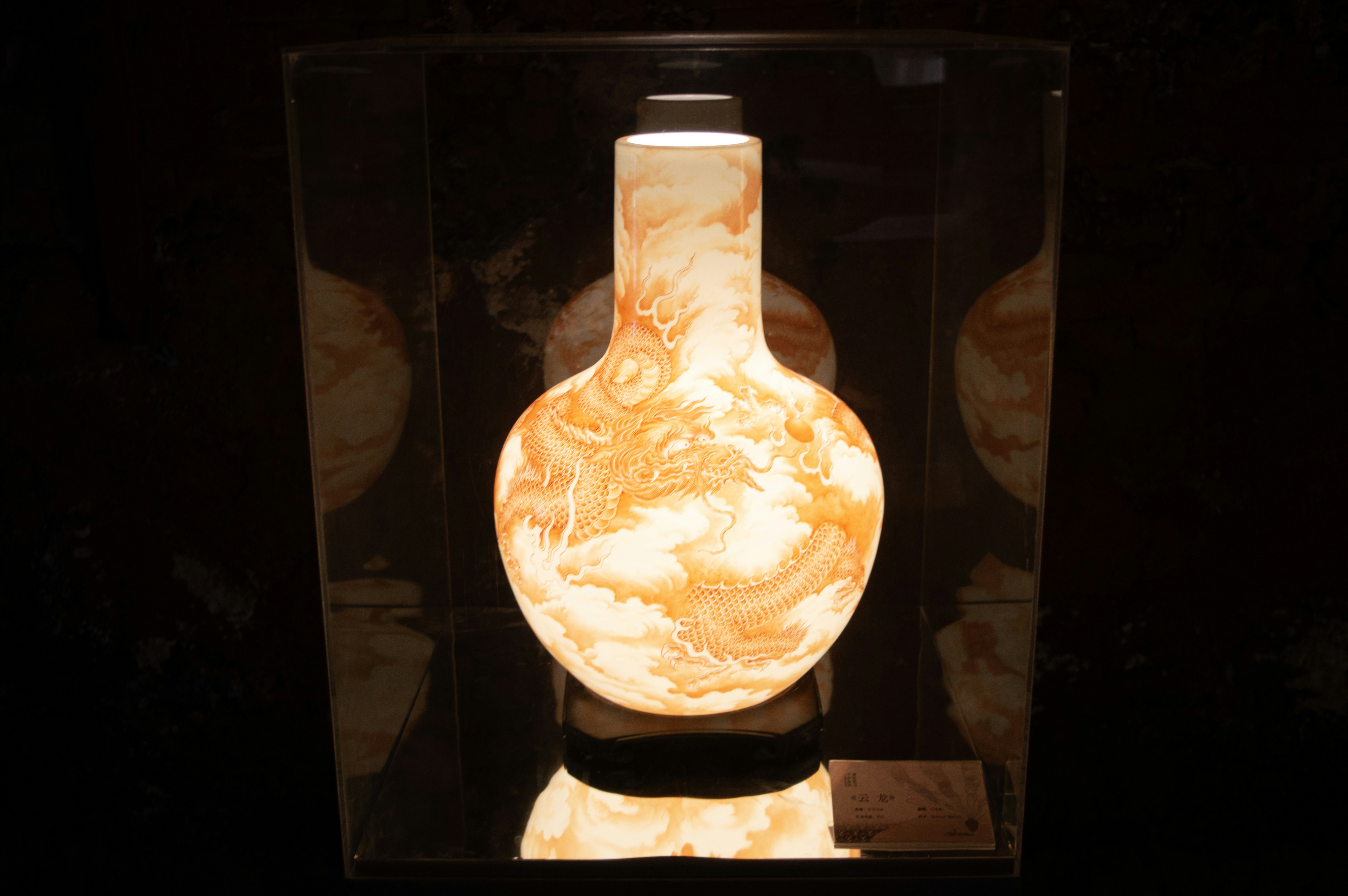 Glowing Ceramic Vase on Display: Soft Mandarin Motif Under Spotlight