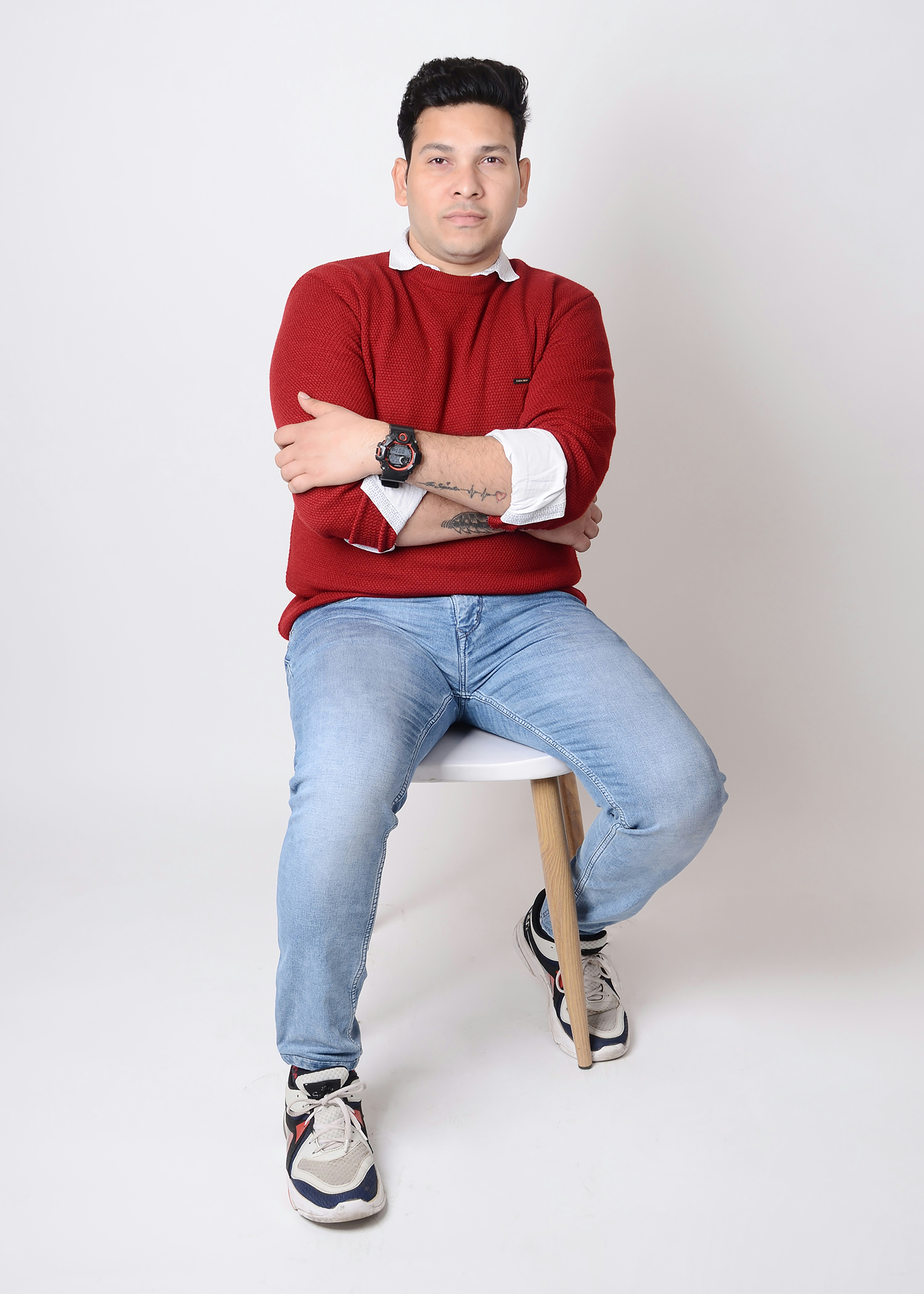 Casual Confidence: A Man in Red Sweater Anchors a Studio Portrait