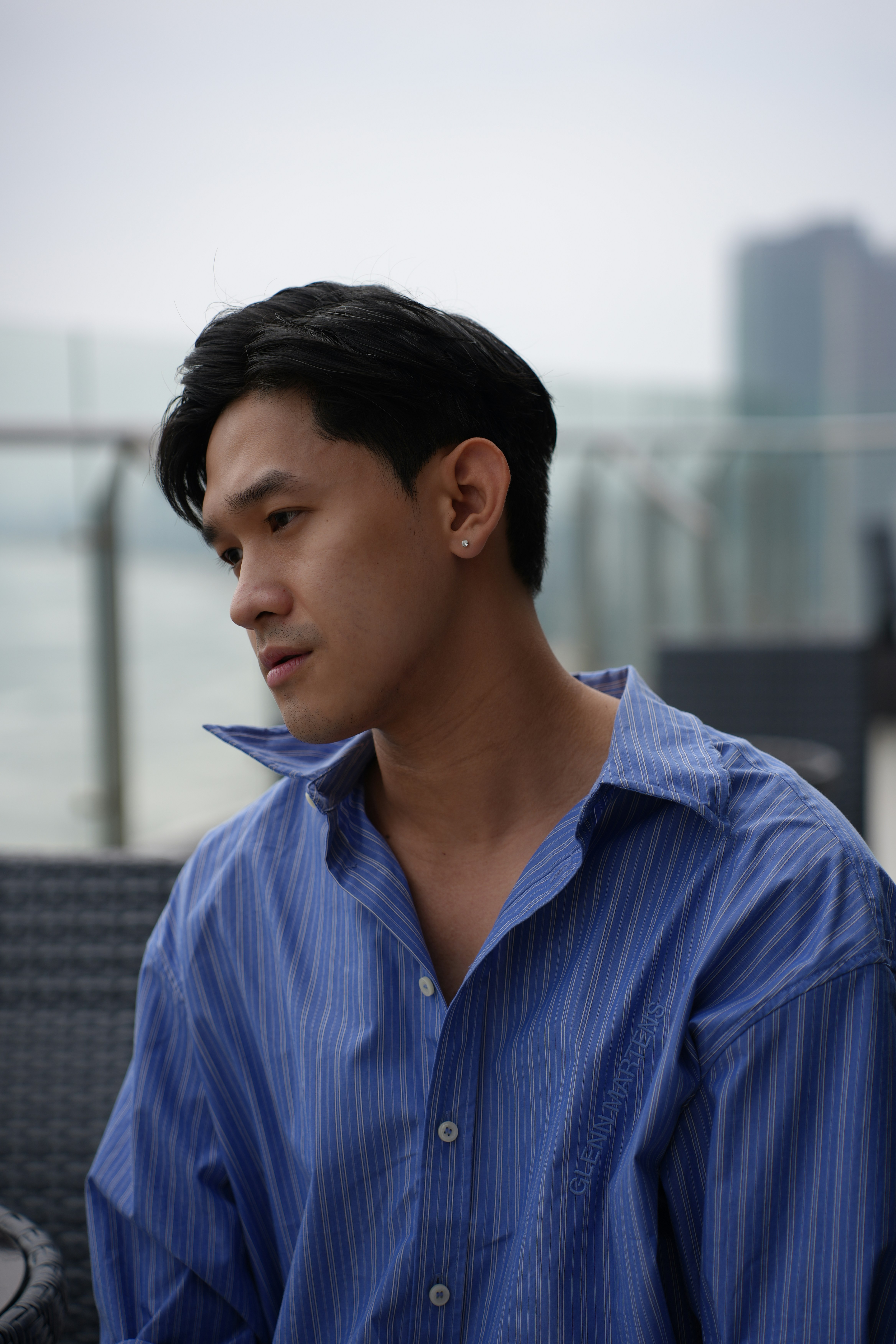 Portrait on the Rooftop: Focused Contemplation in Blue Stripes