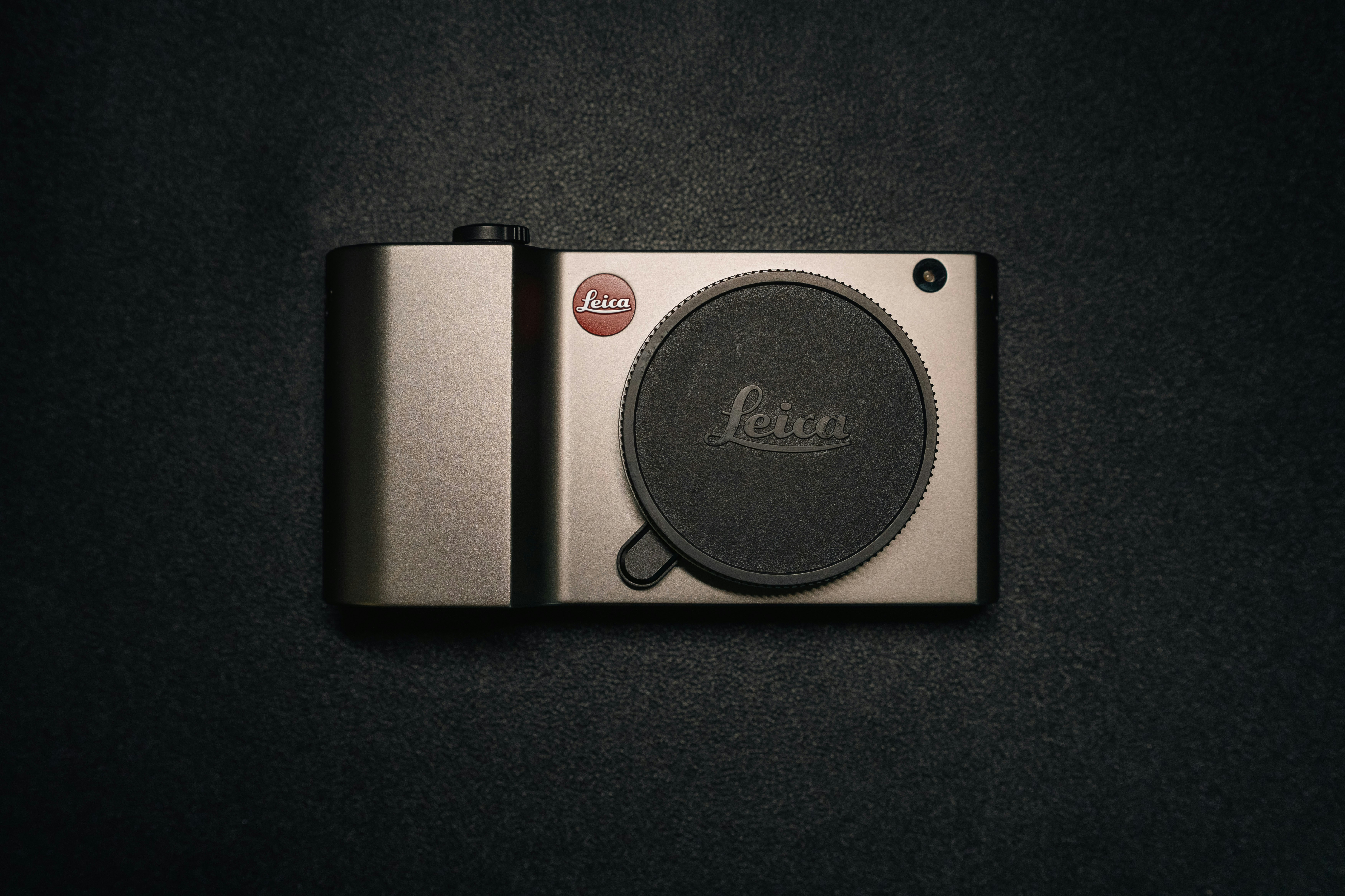 Minimalist Leica Moment: Matte Silver Compact on a Dark Backdrop