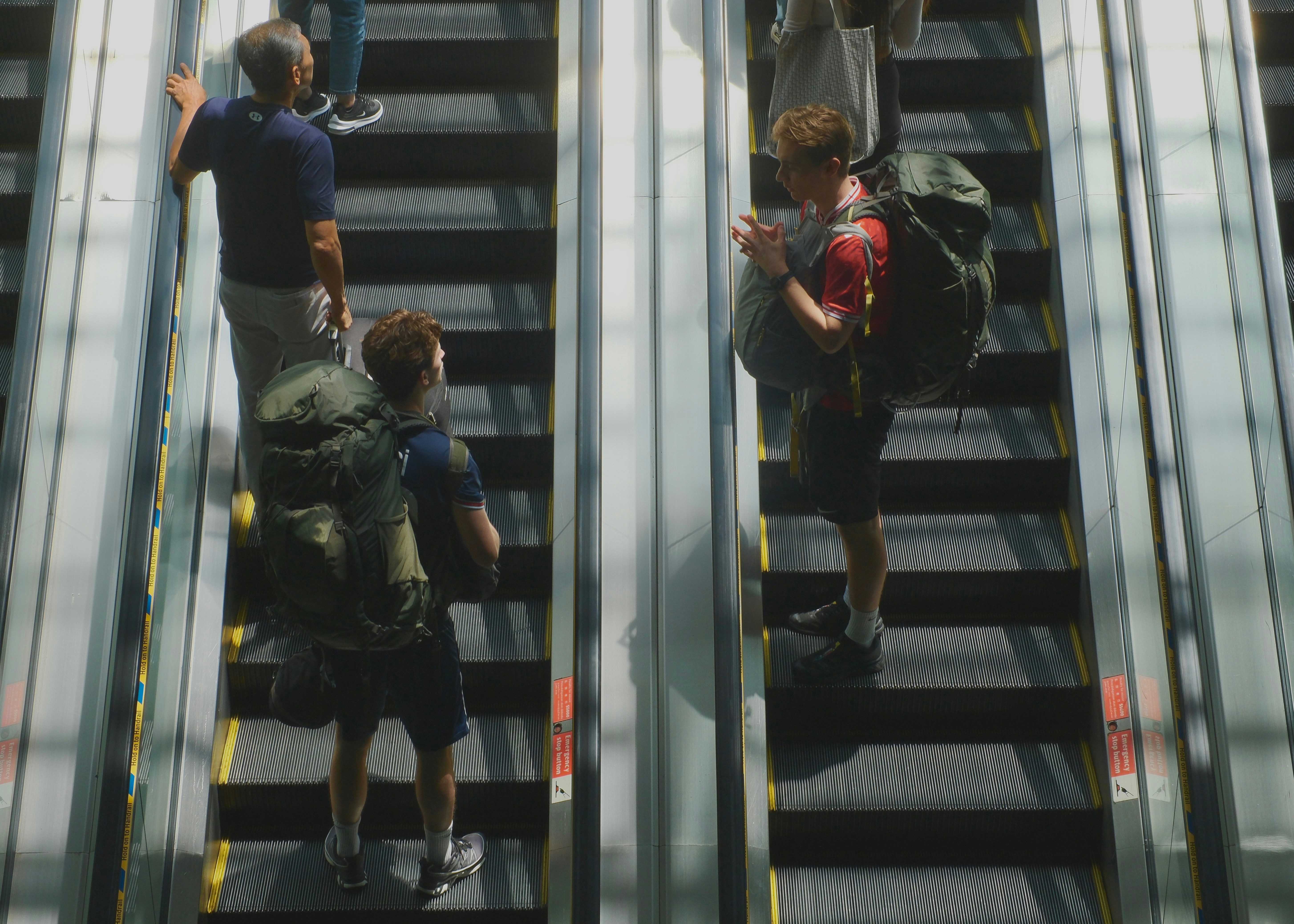 Three Travelers on Escalators: A Moment of Pause Between Journeys