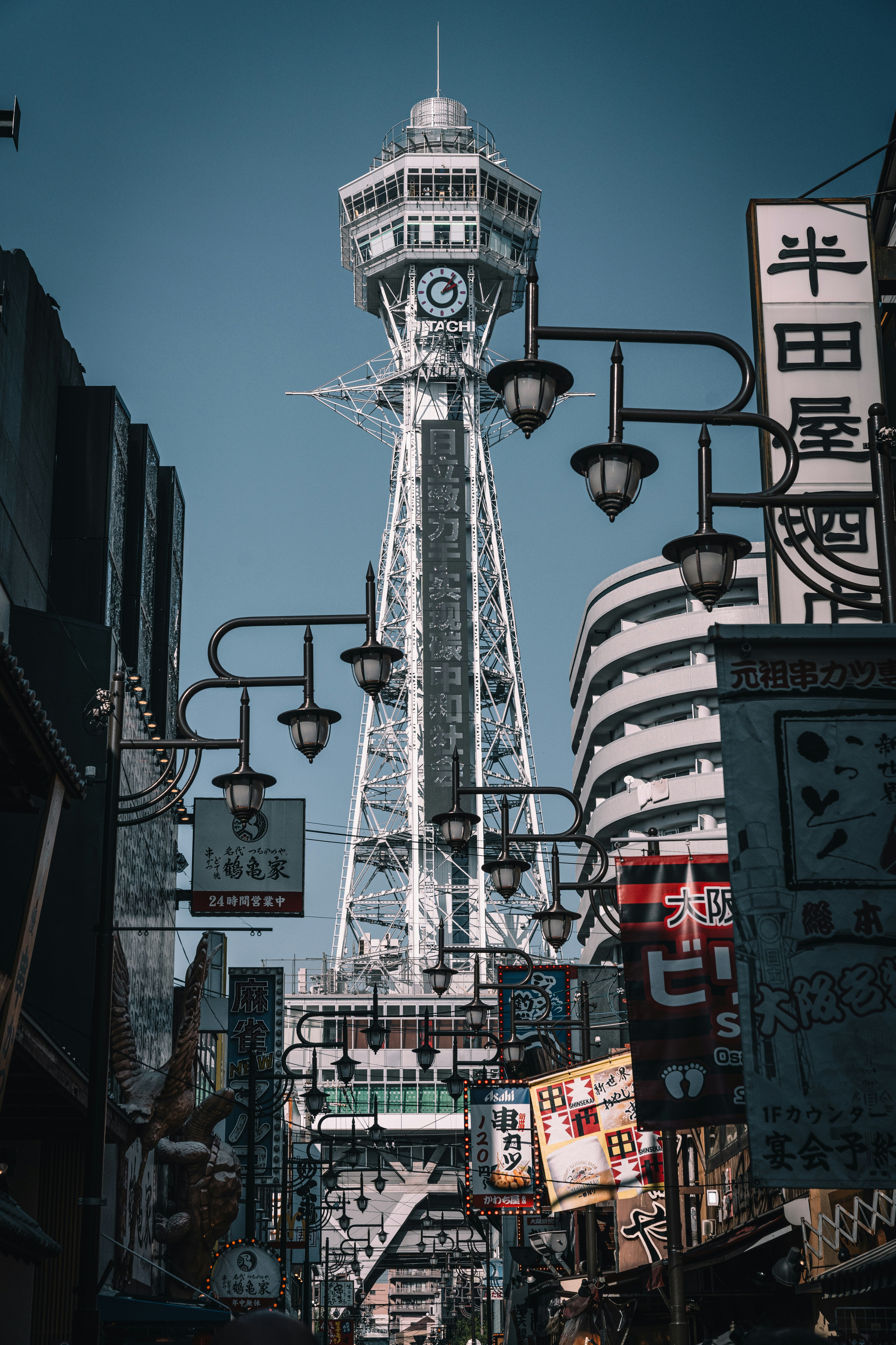 Towering Neon Pulse: Nippon's Signal Amid the Street Lanterns