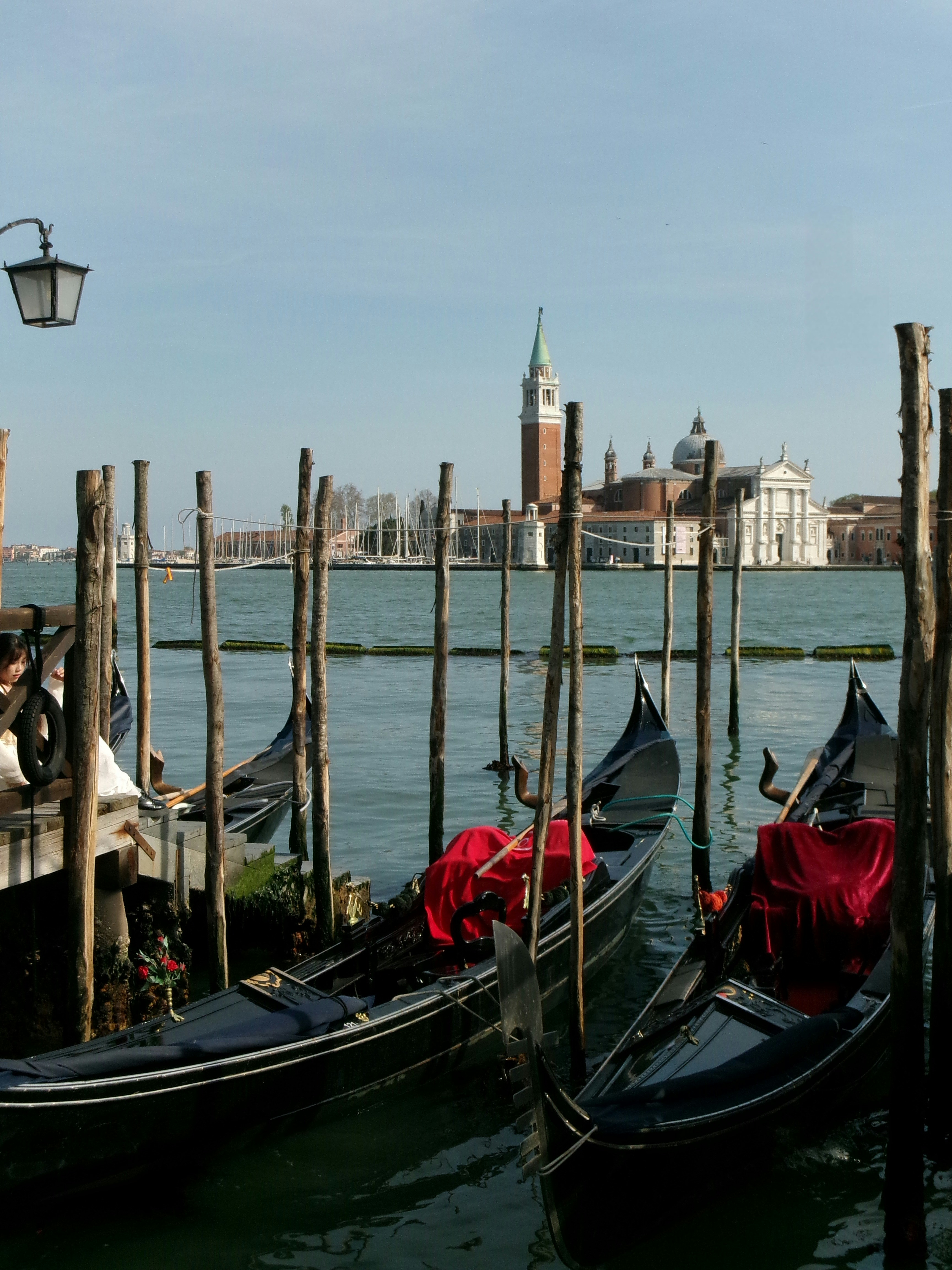 Gondolas docked on a canal with buildings in background