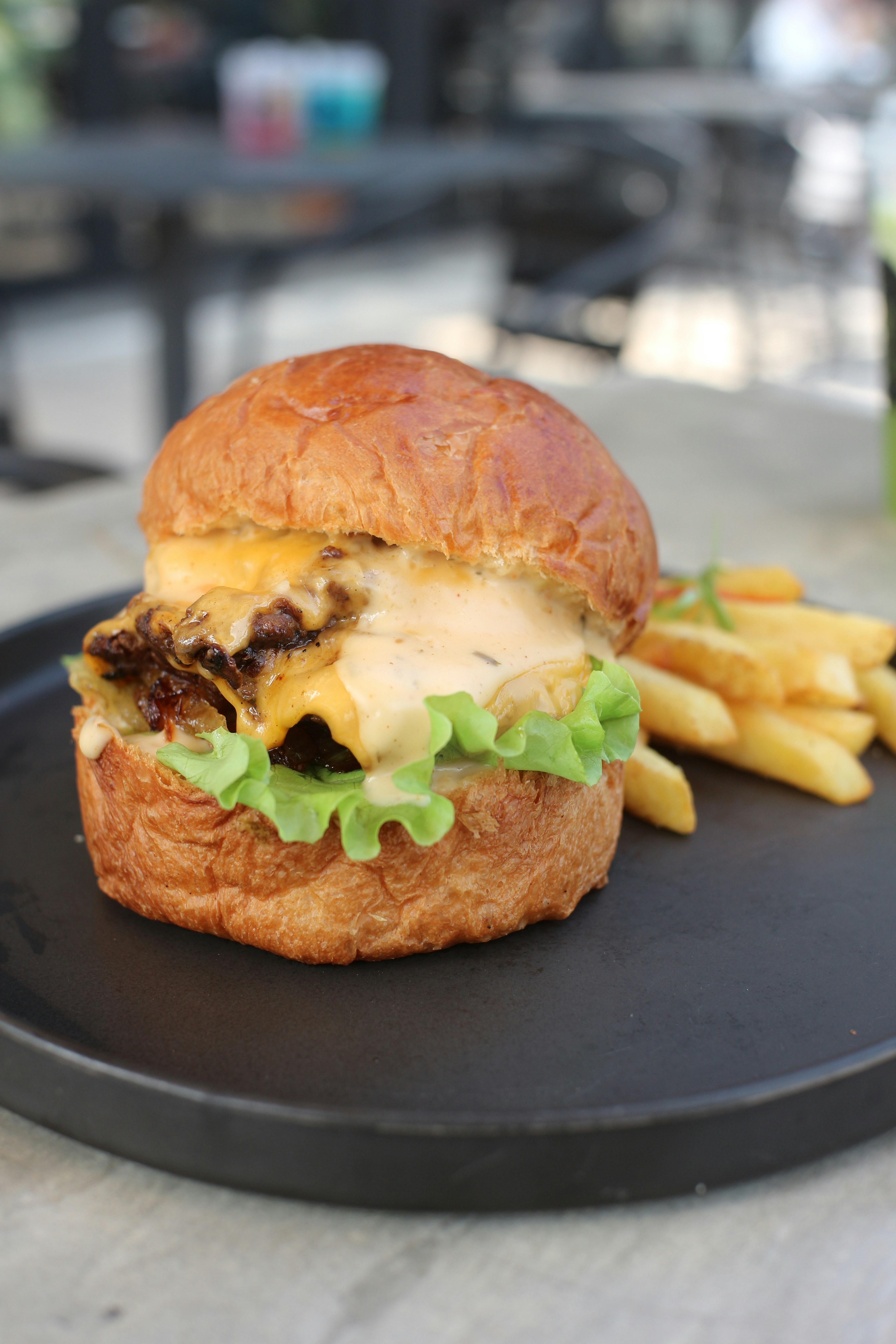 Savory Stack: Cheese-molten Burger on a Slate with Crispy Fries