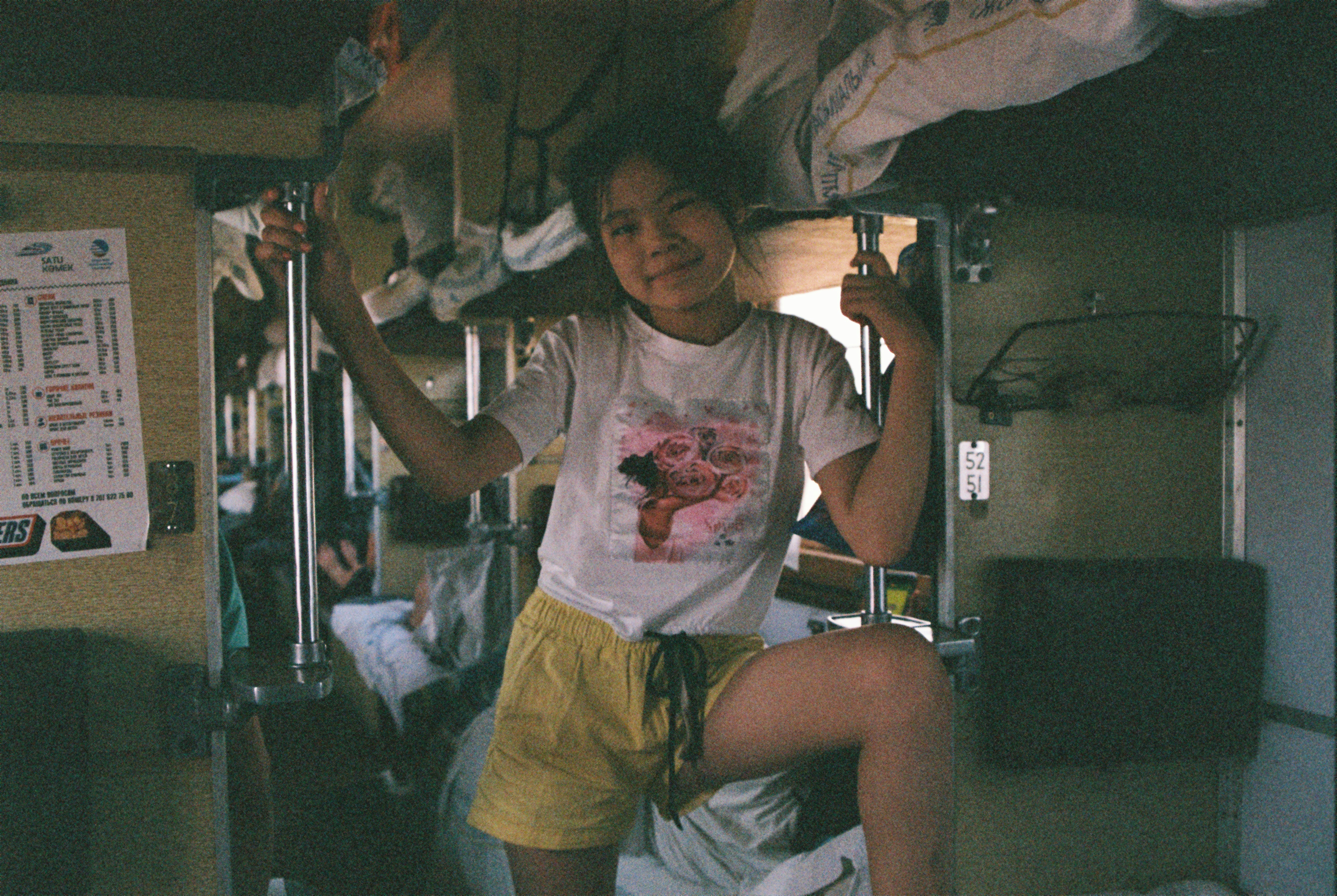 Underside Adventure: A Queue of Steps and a Smiling Climber in a Train Car