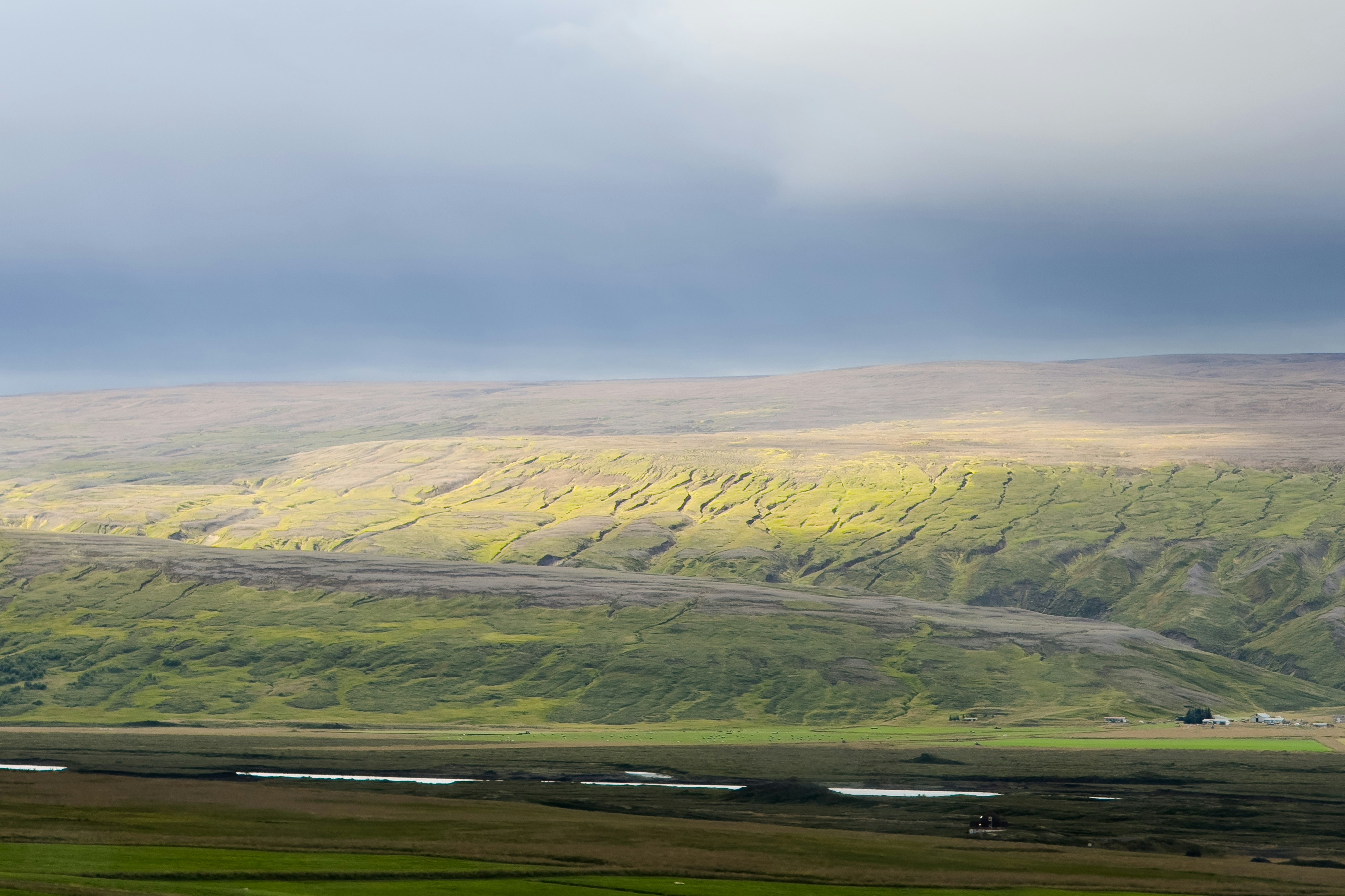Sunlit Serpentine Hills Over Lowland Marsh