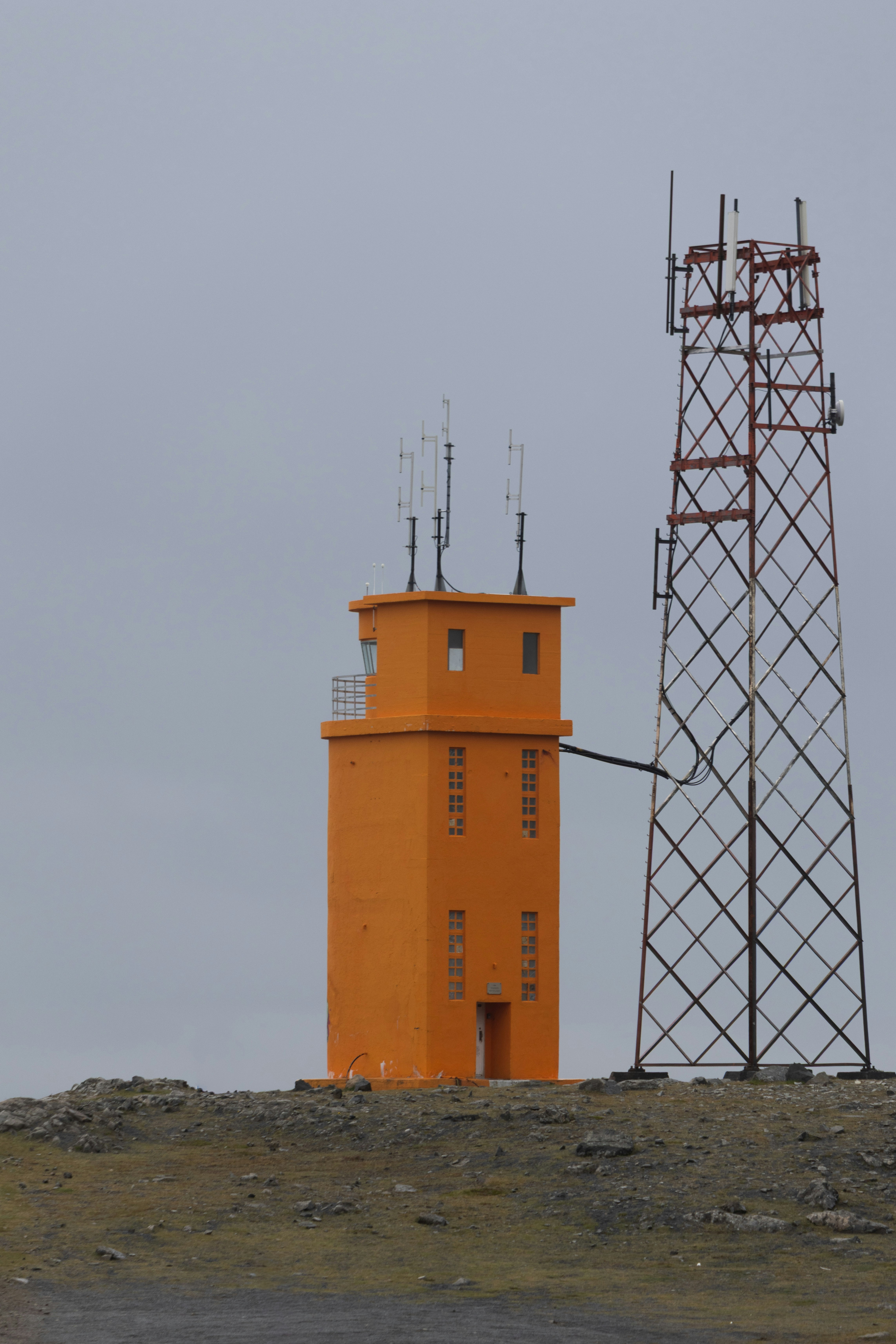 Orange beacon: a lone towerscape against a cloudy horizon
