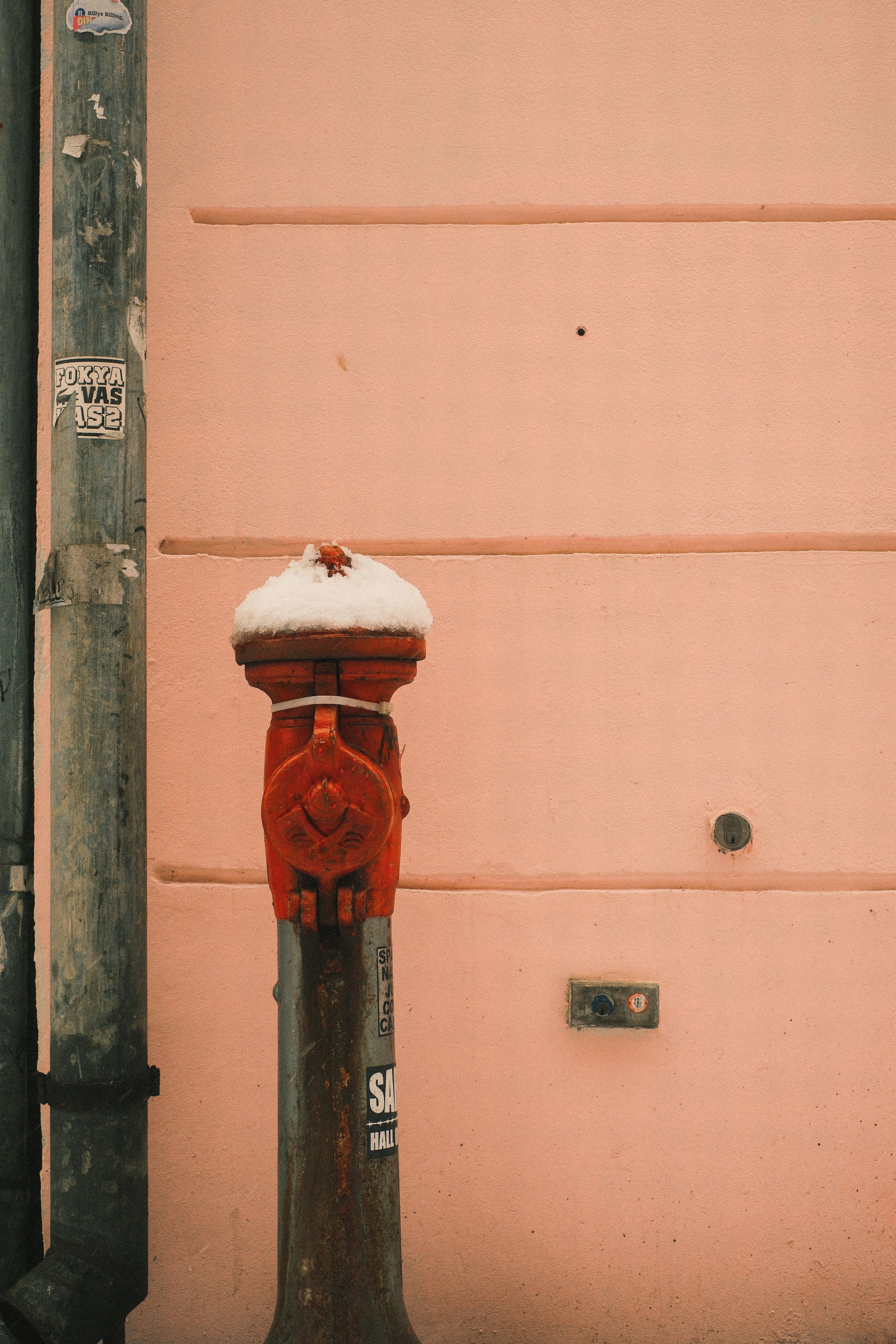 Snowy fire hydrant against pastel wall
