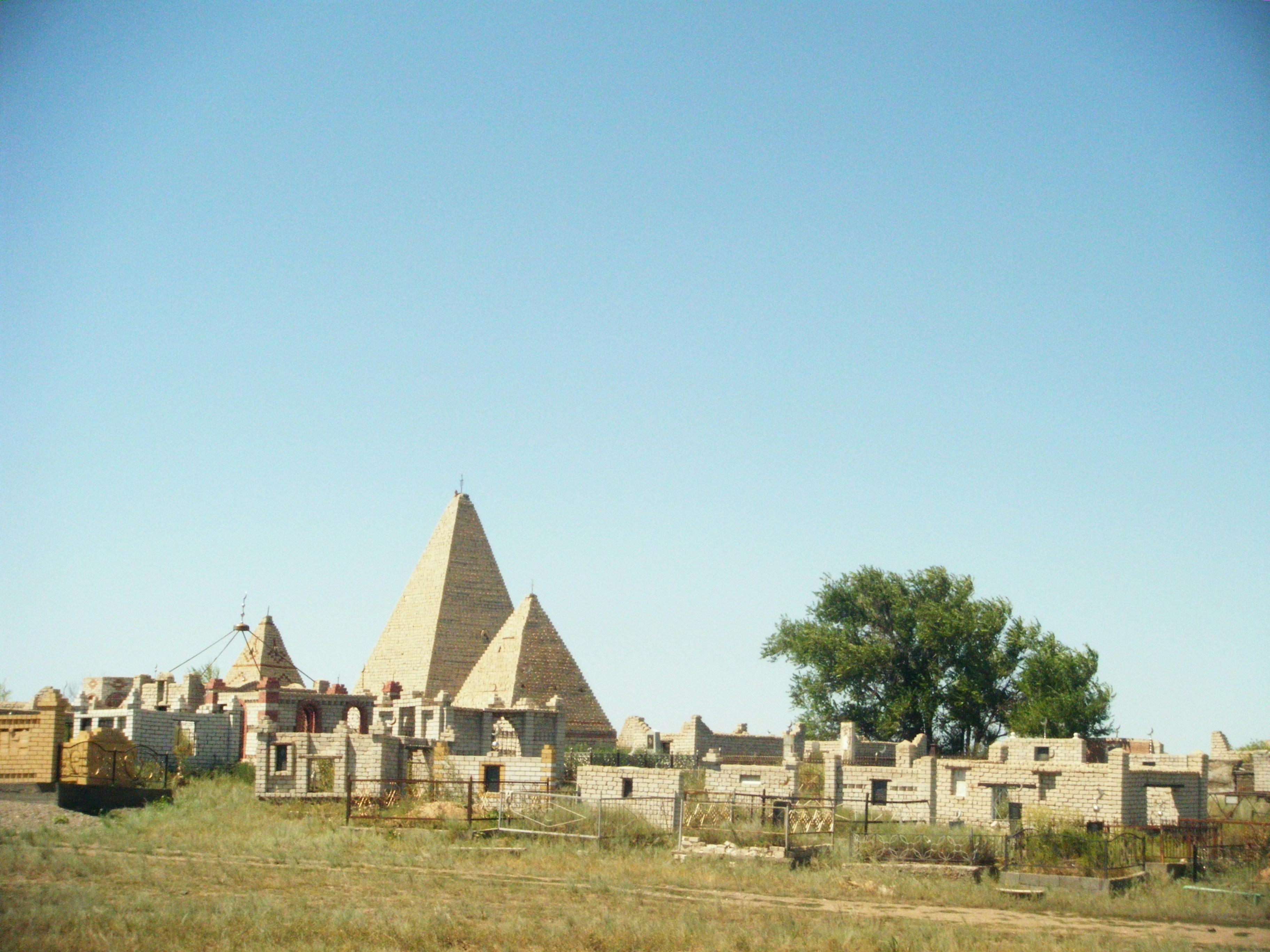Ancient egyptian pyramids and structures under a clear blue sky.