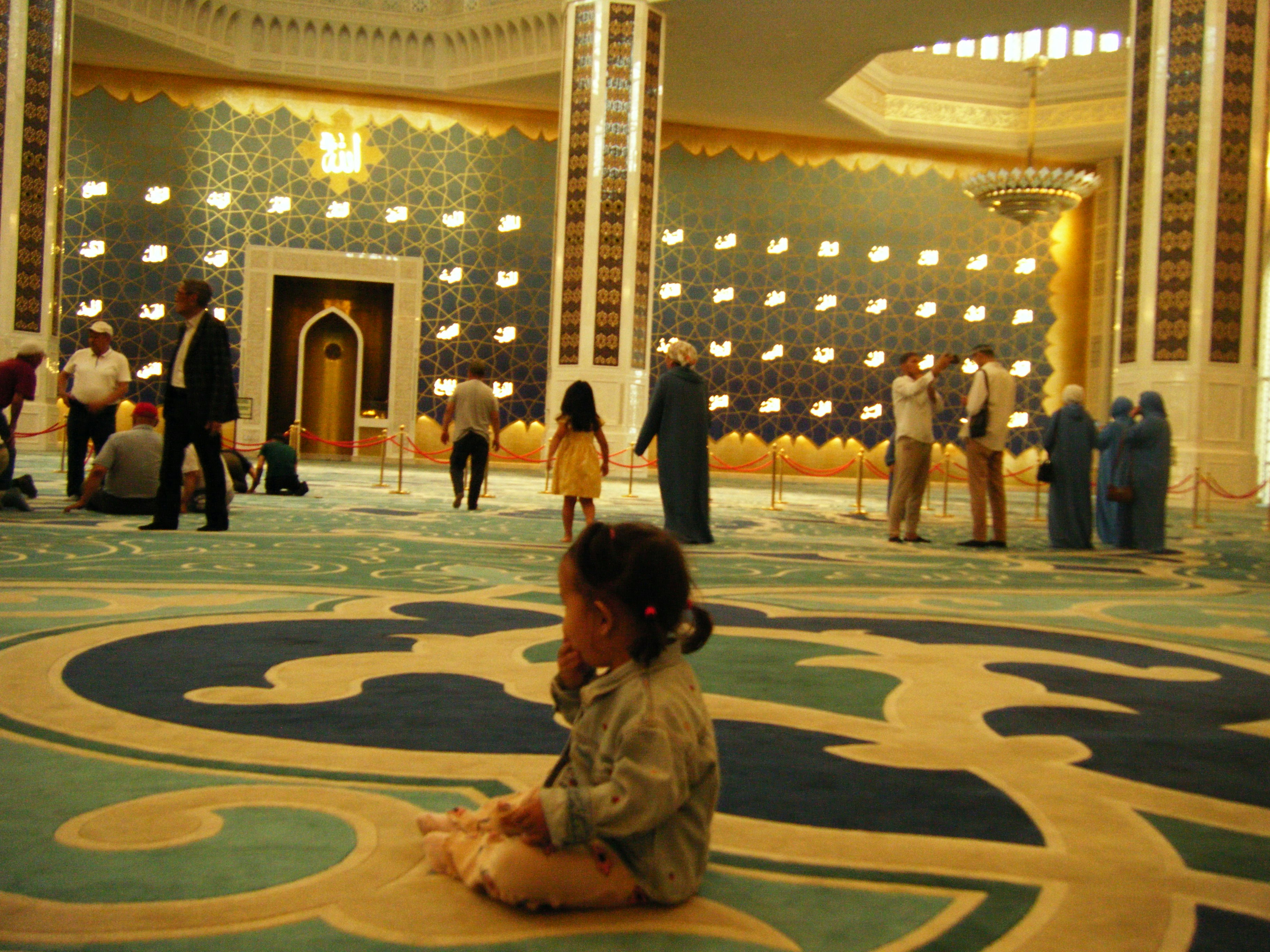 People gathered in a large, ornate mosque interior
