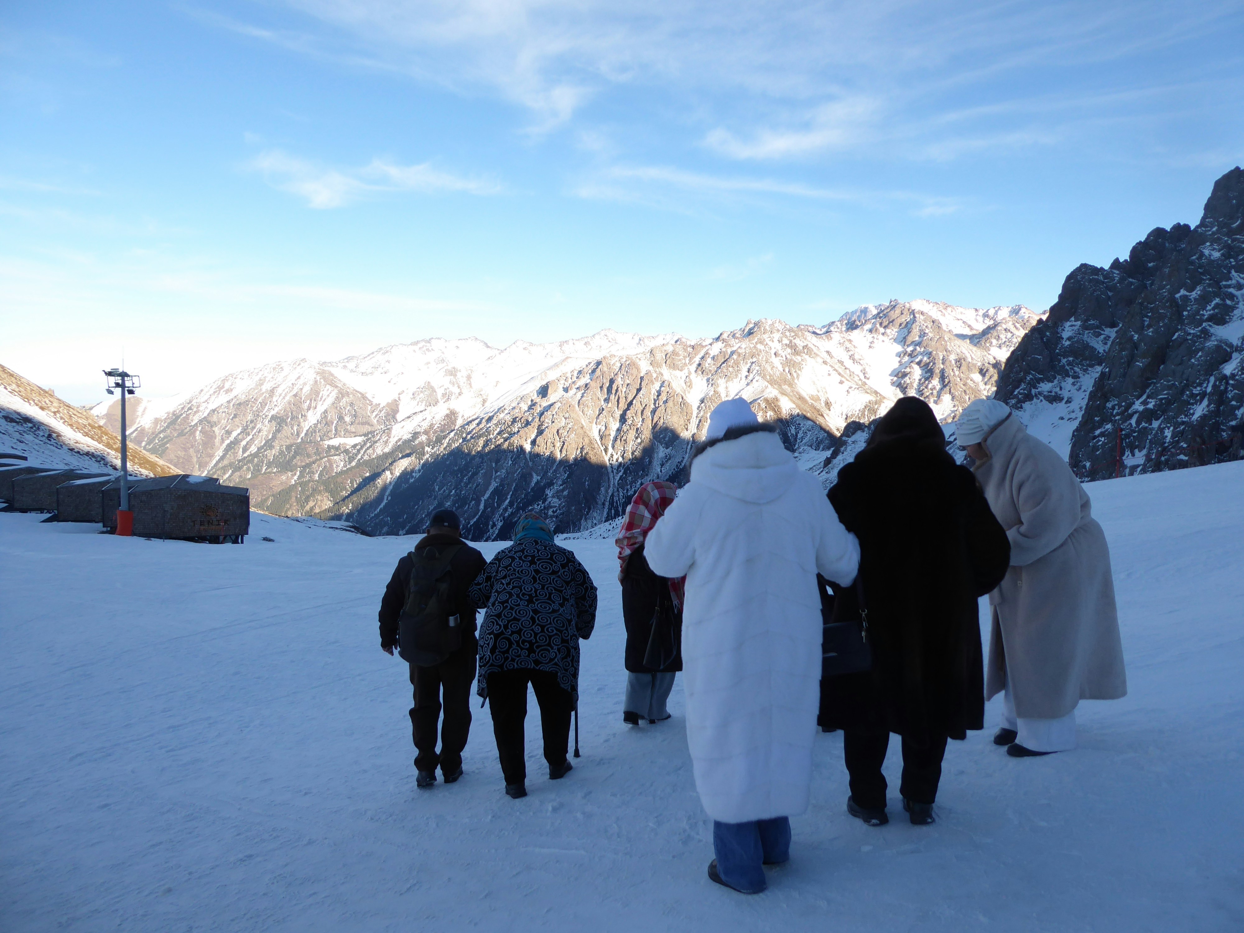 People walking on a snow-covered mountain path