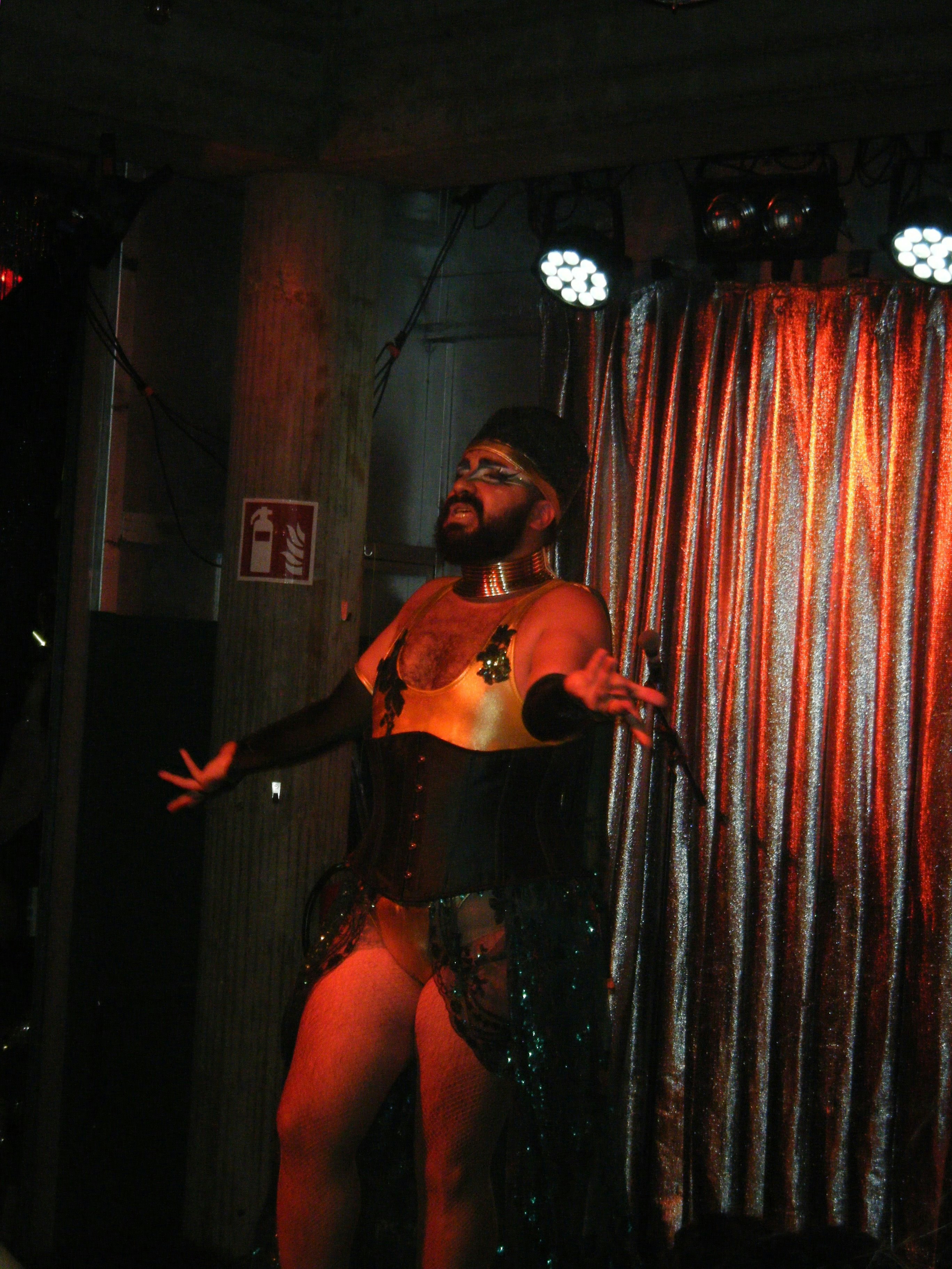 A drag performer in a sparkly outfit on stage.