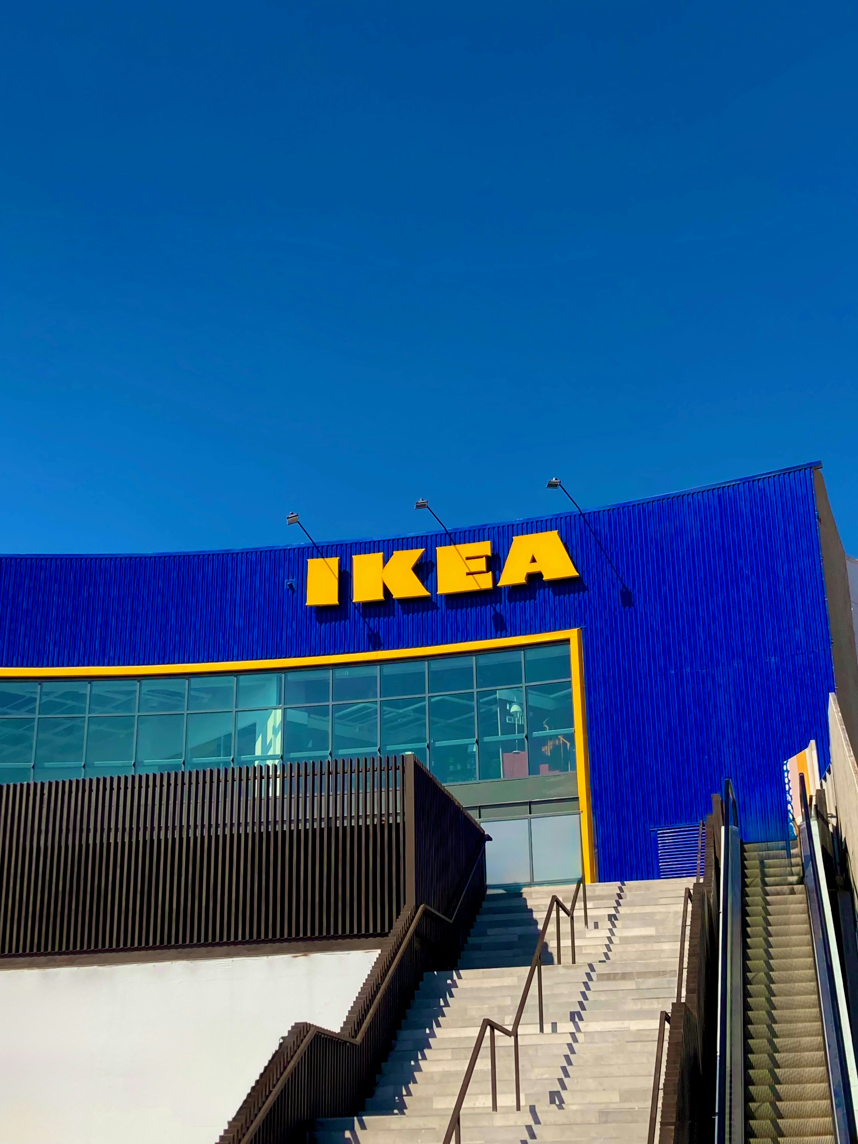 Bold Blue Facade: An IKEA Corner Ascending with Stairs and Sunlit Sky