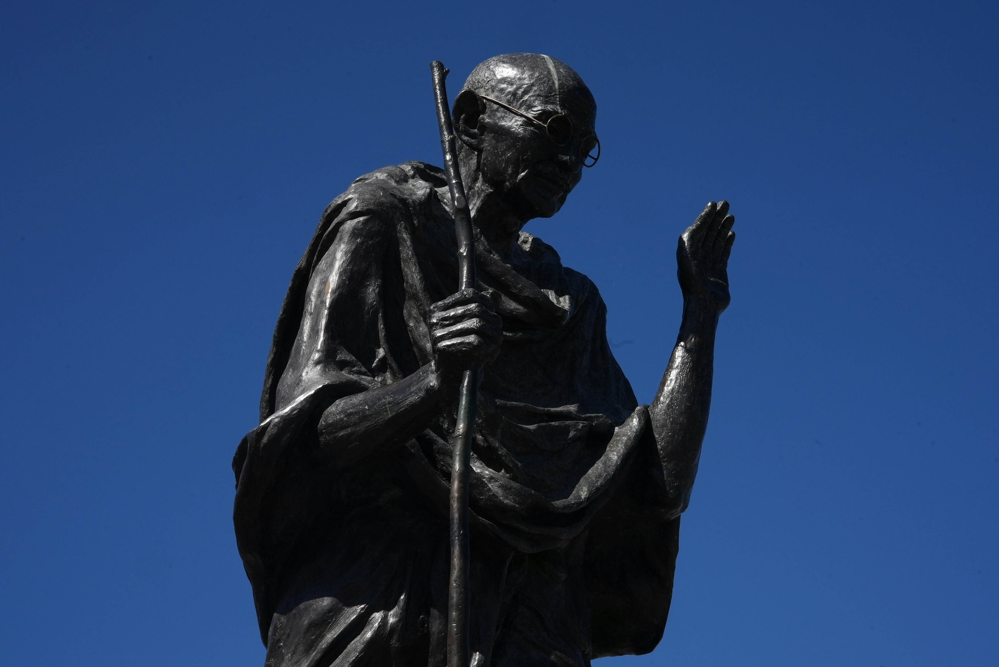 Scholar in Shadow: A Stoic Bronze Figure Reaching Toward the Sky