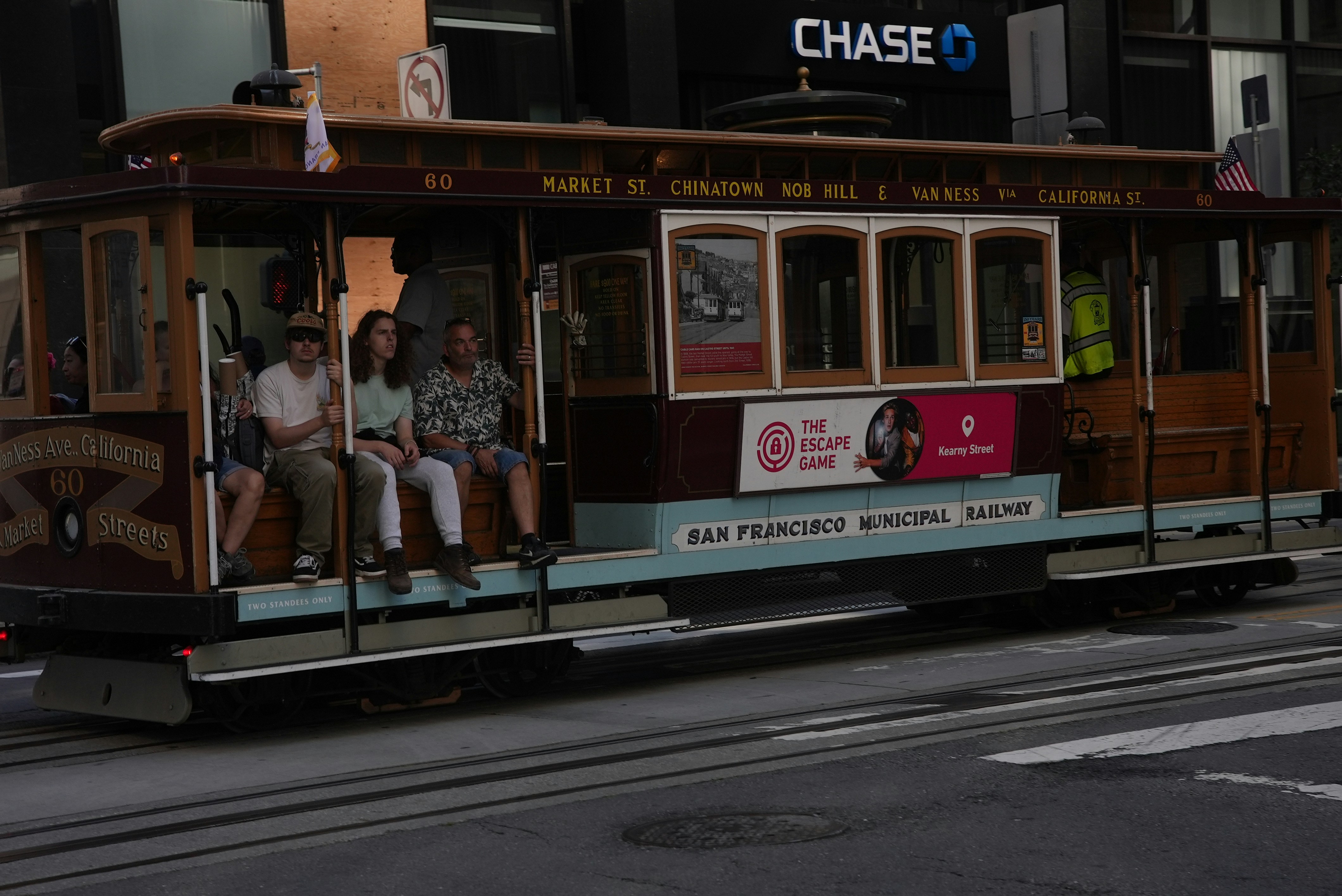 Historic Cable Car in Motion: Riders Pause on a San Francisco Streetcar