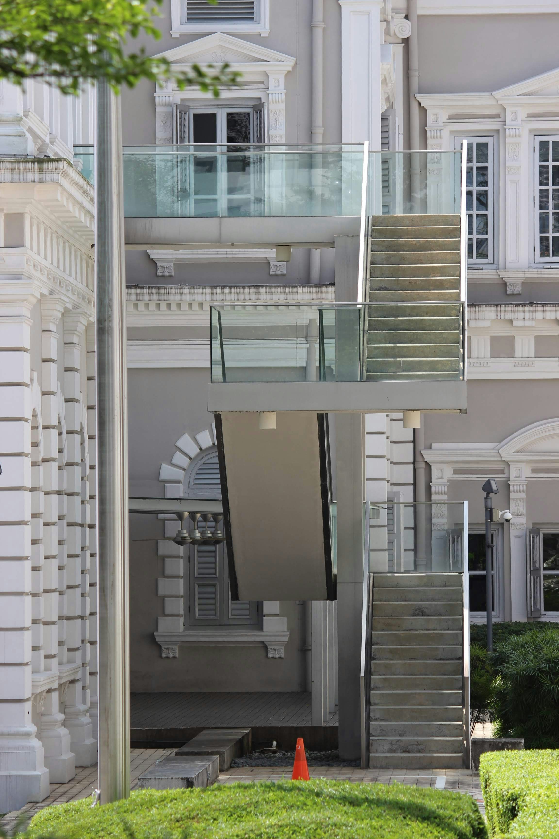 Glass and Stone Staircase: A Modern Apparatus Against Classical Facades