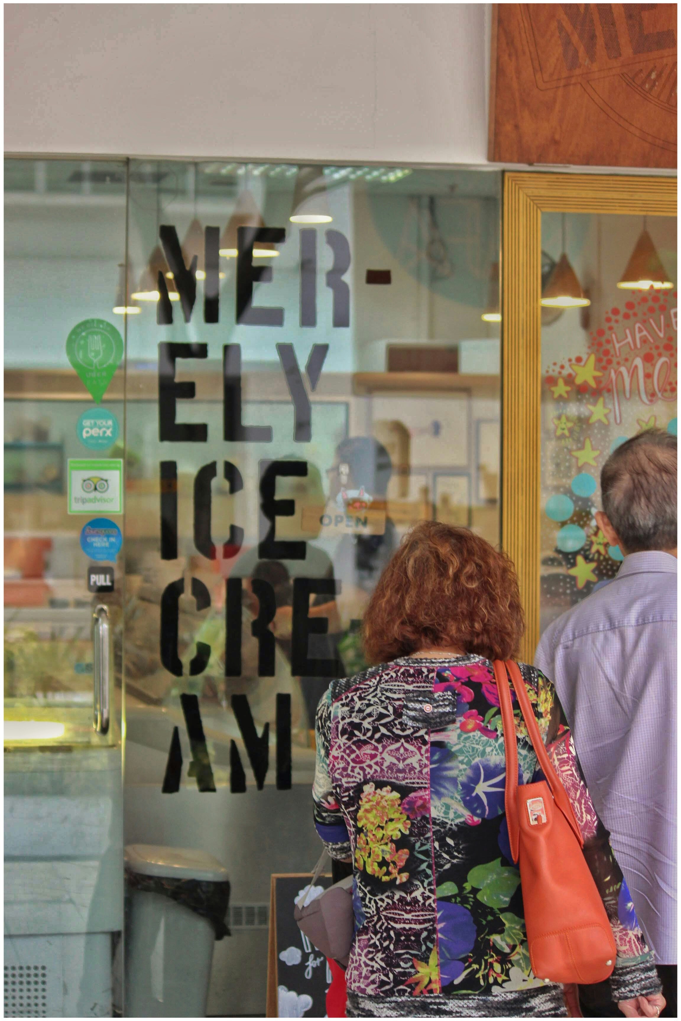Colorful Back to Work: A Floral Jacket Faces a Glass Door Advertisement