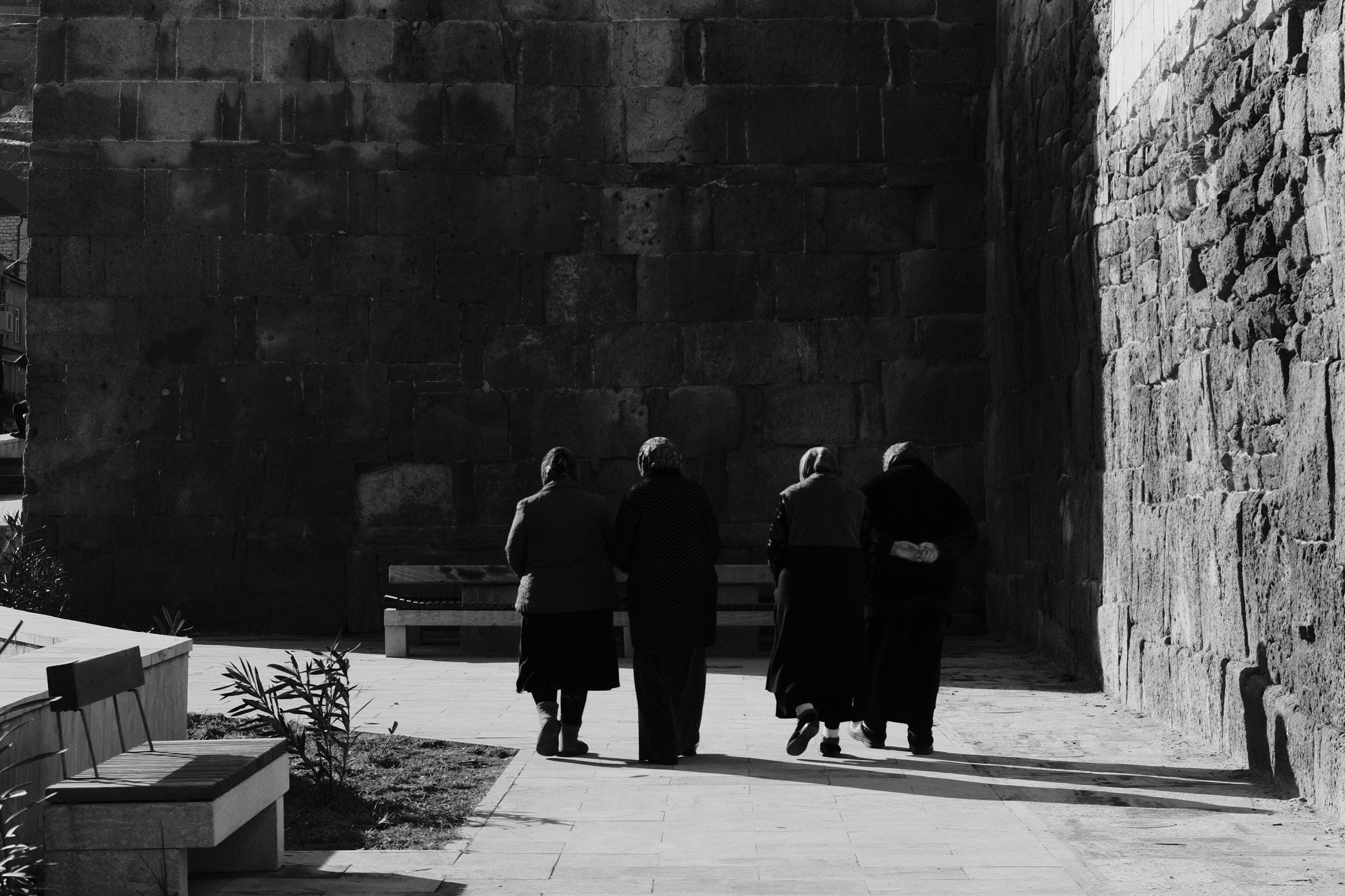 Silent stride: monks returning through a sunlit fortress