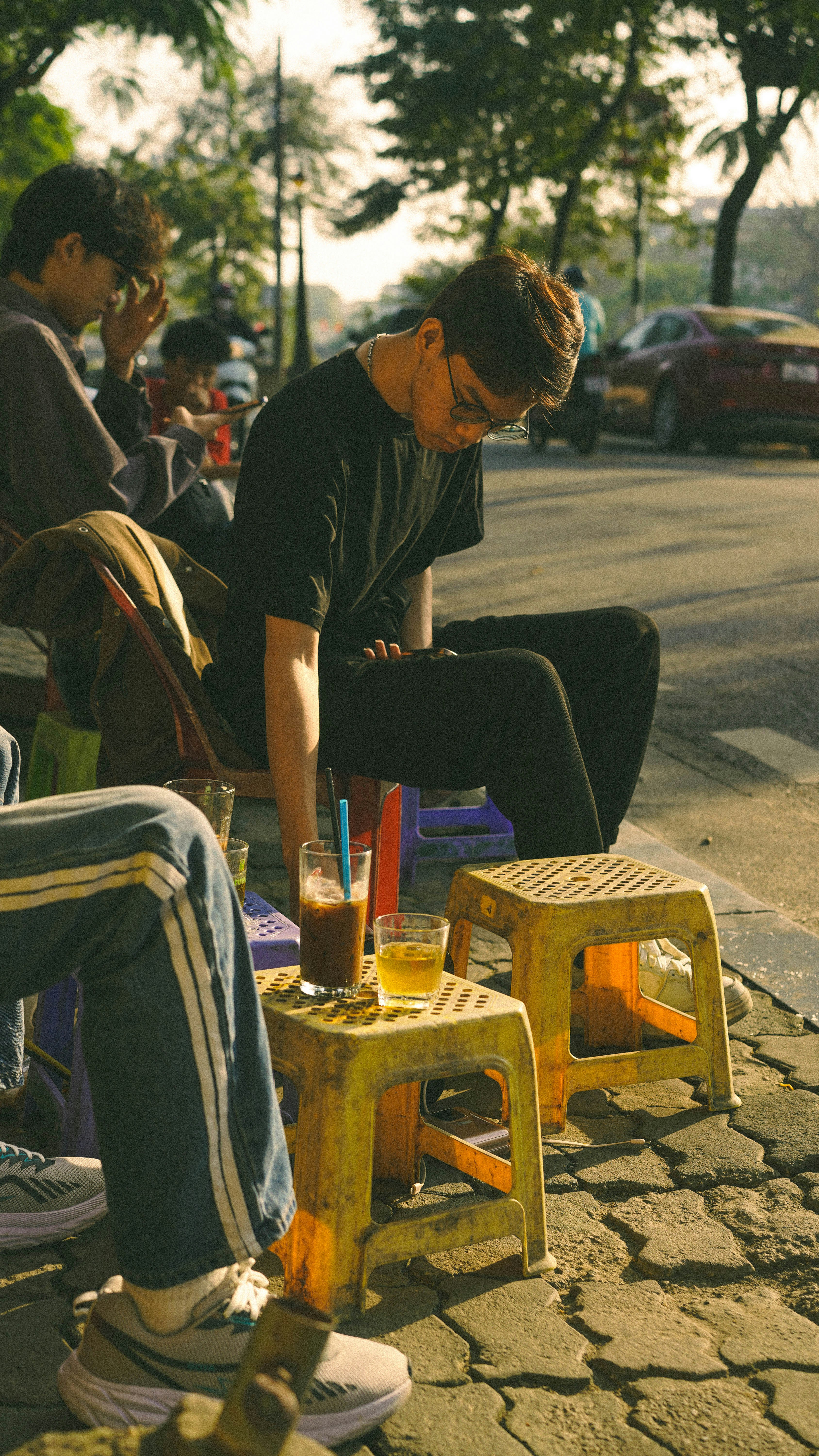 Streetside Focus: The Quiet Moment of a Young Man in Shade