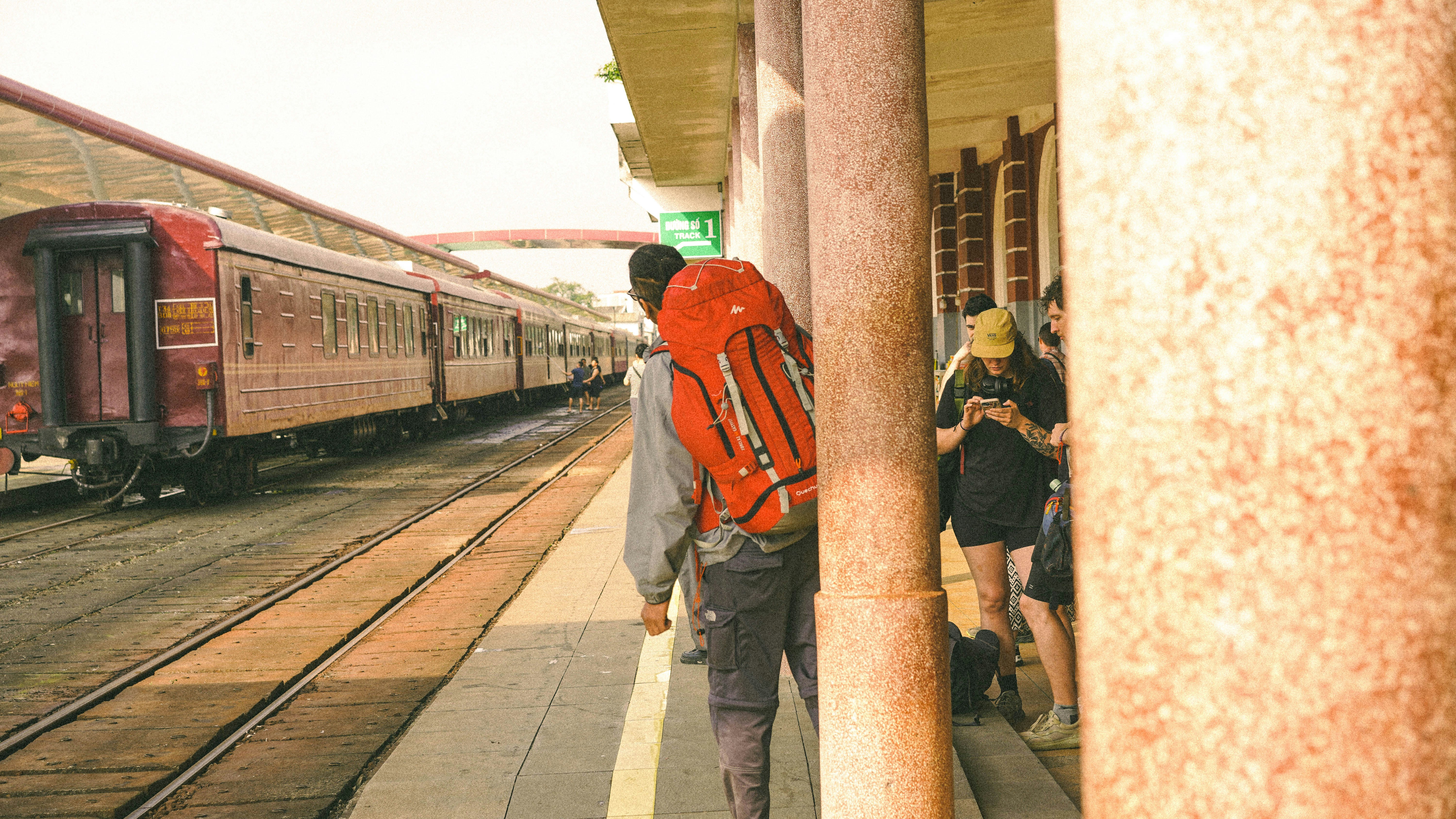 Platform Pause: Travelers at a Rushing Station