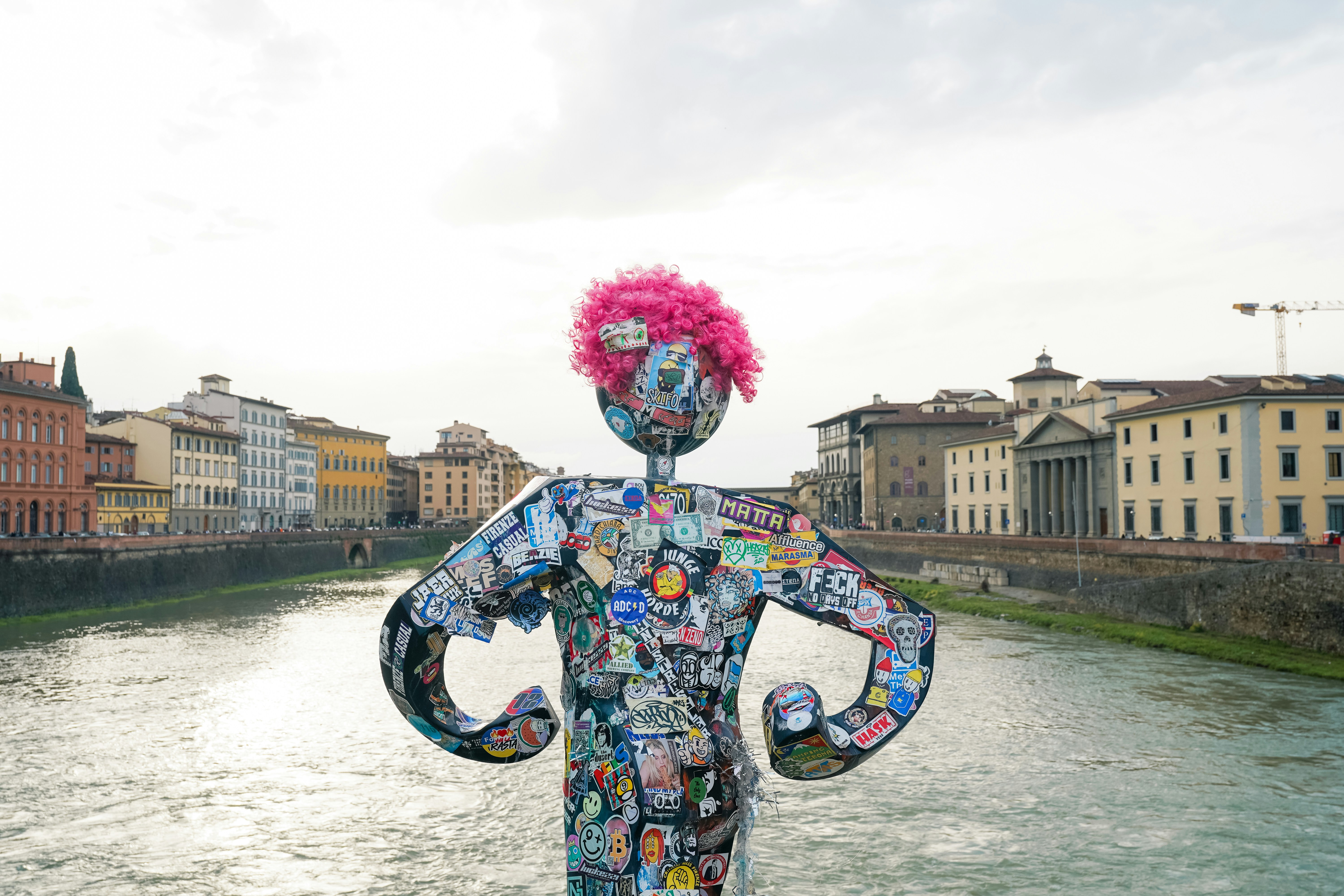 Collage of Color: A Public Art Figure in a Riverside Italian Street Scene