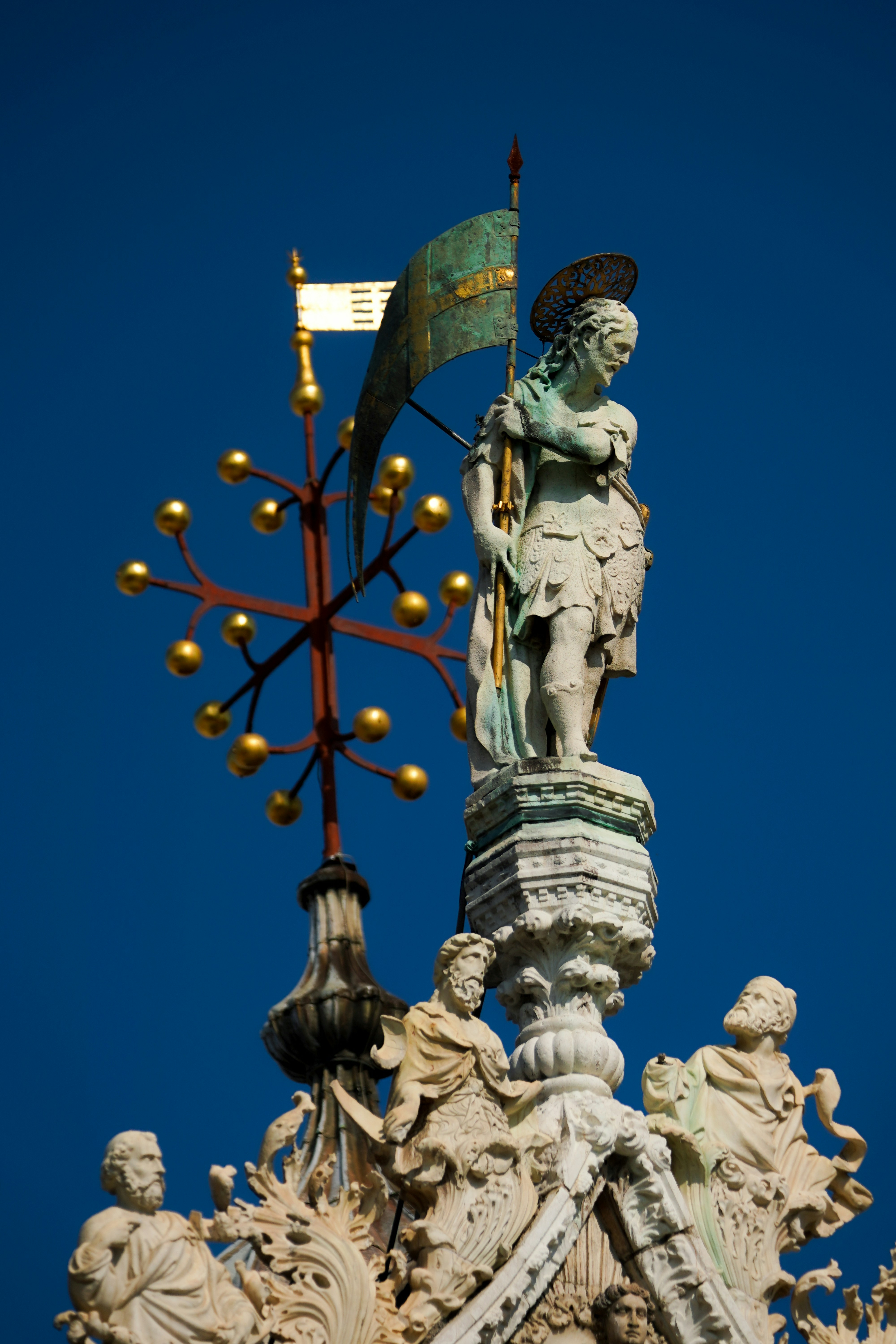 Angelic Statue Above Carved Plinth Under a Deep Blue Sky