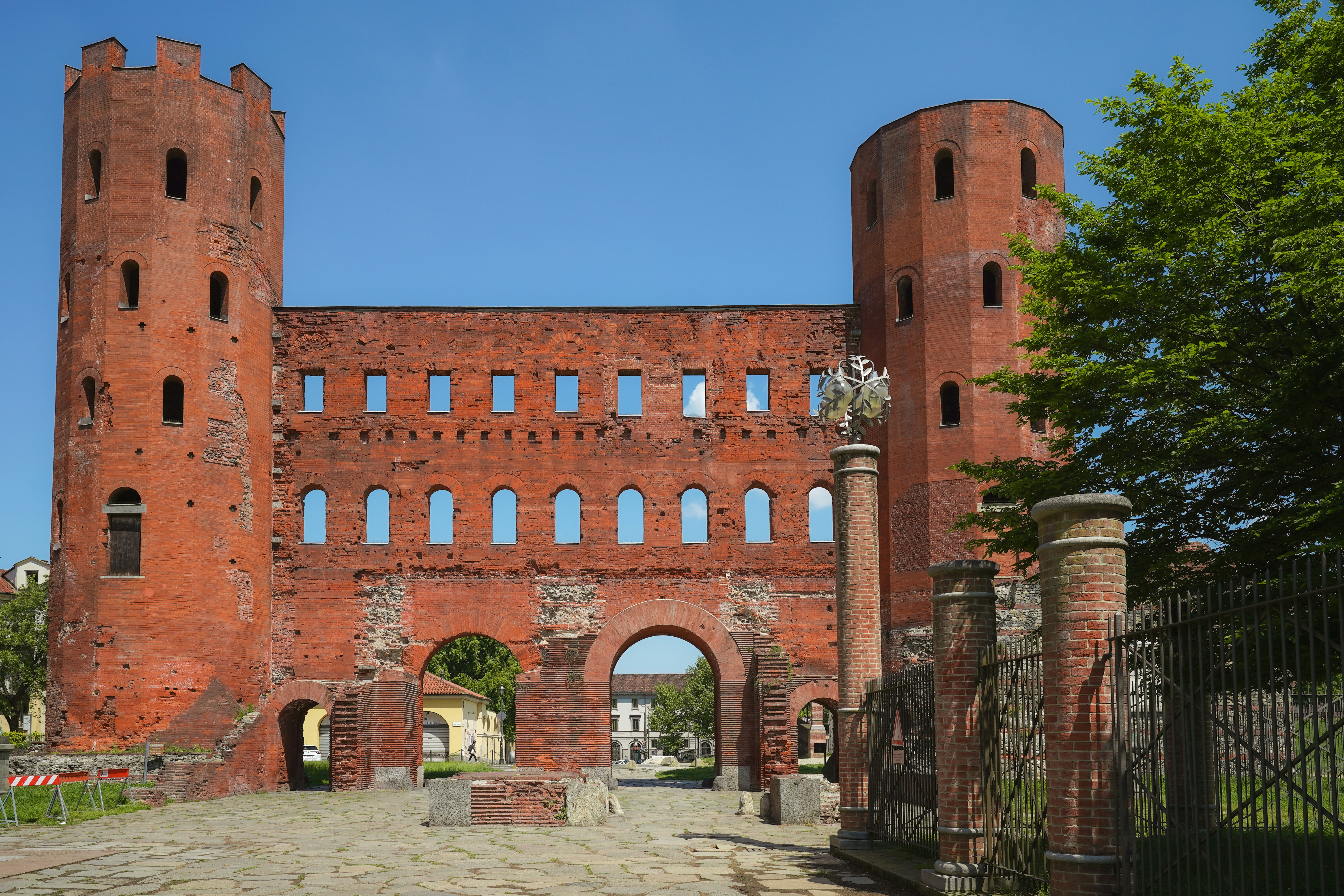 Ruins of Red Brick Gatehouse Framed by Cast Shadows and Blue Sky