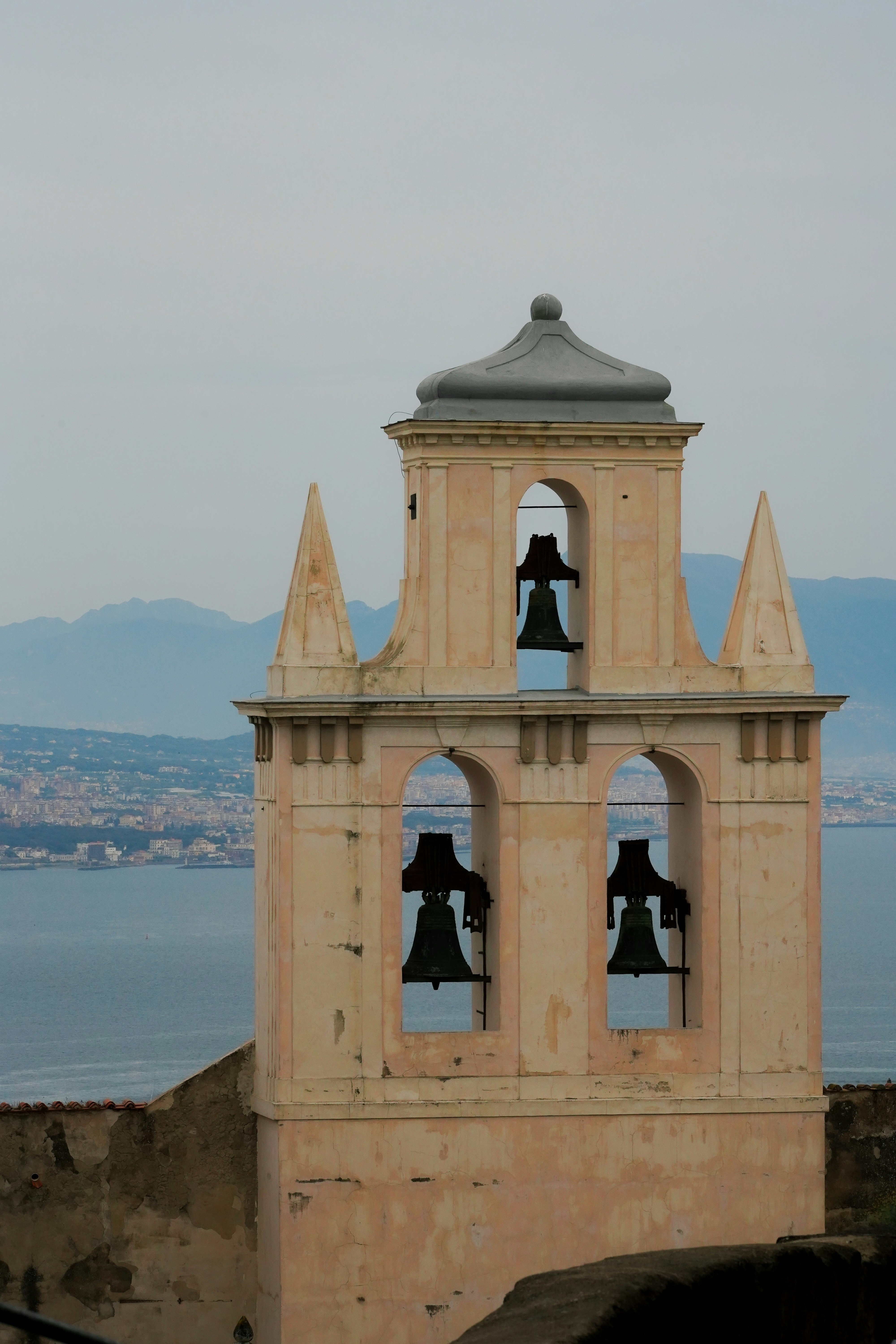 Bell Tower Vista: A Seaside Chapel's Gilded Facade and Distant Horizon