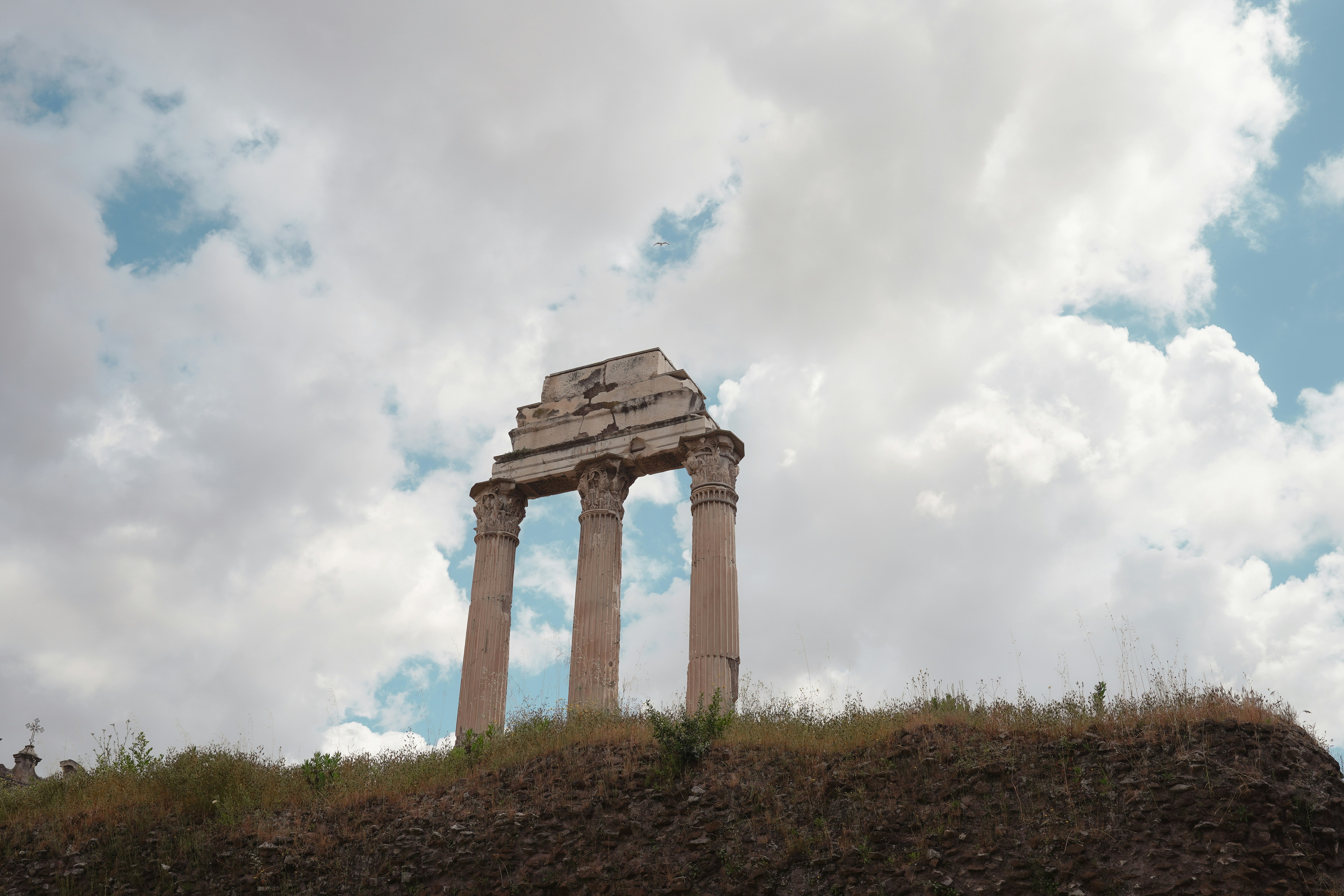 Ruined Temple on a Gentle Hill under a Sky of White Clouds