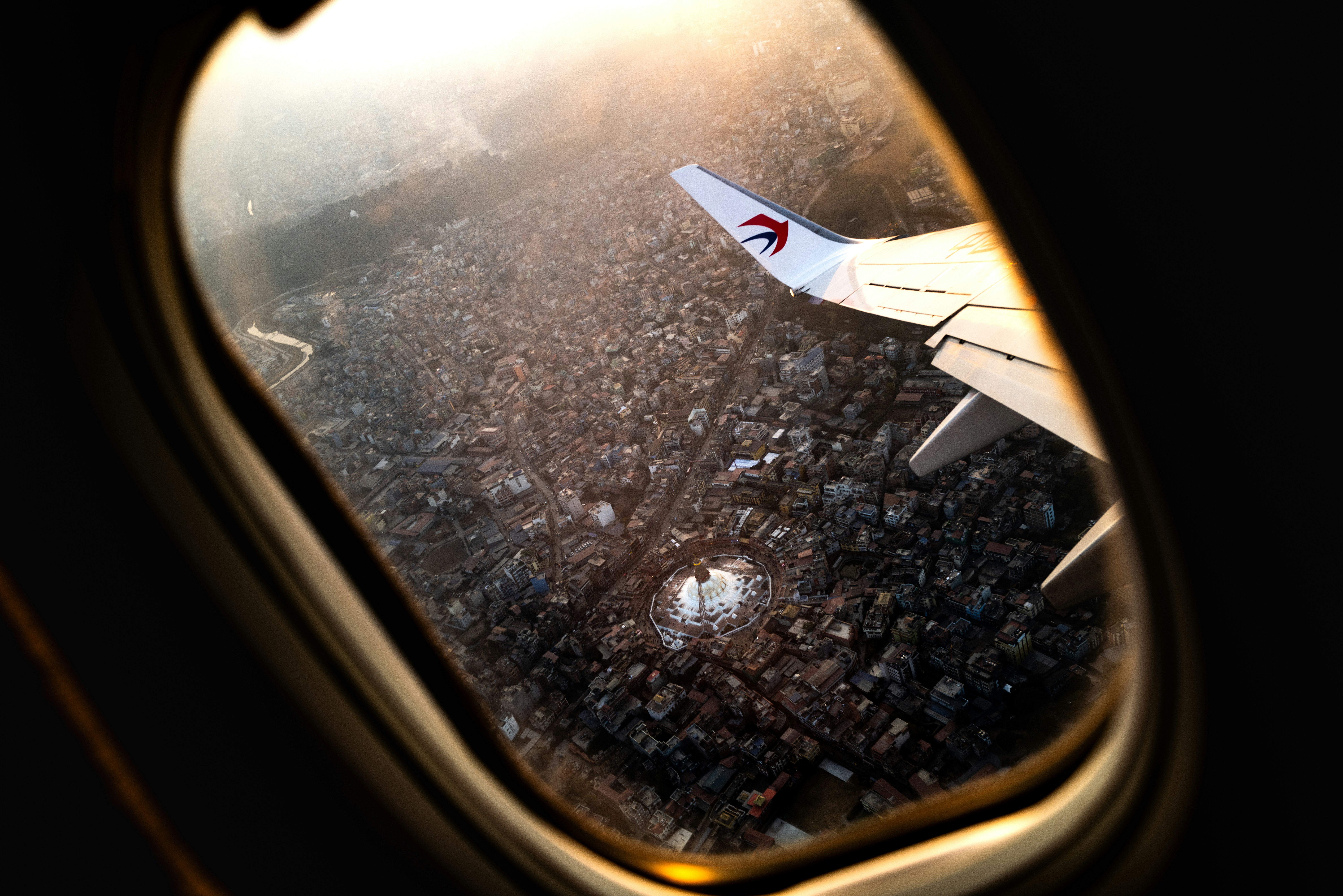 Window Seat View: City Grid Unfolding Beneath a Wingtip